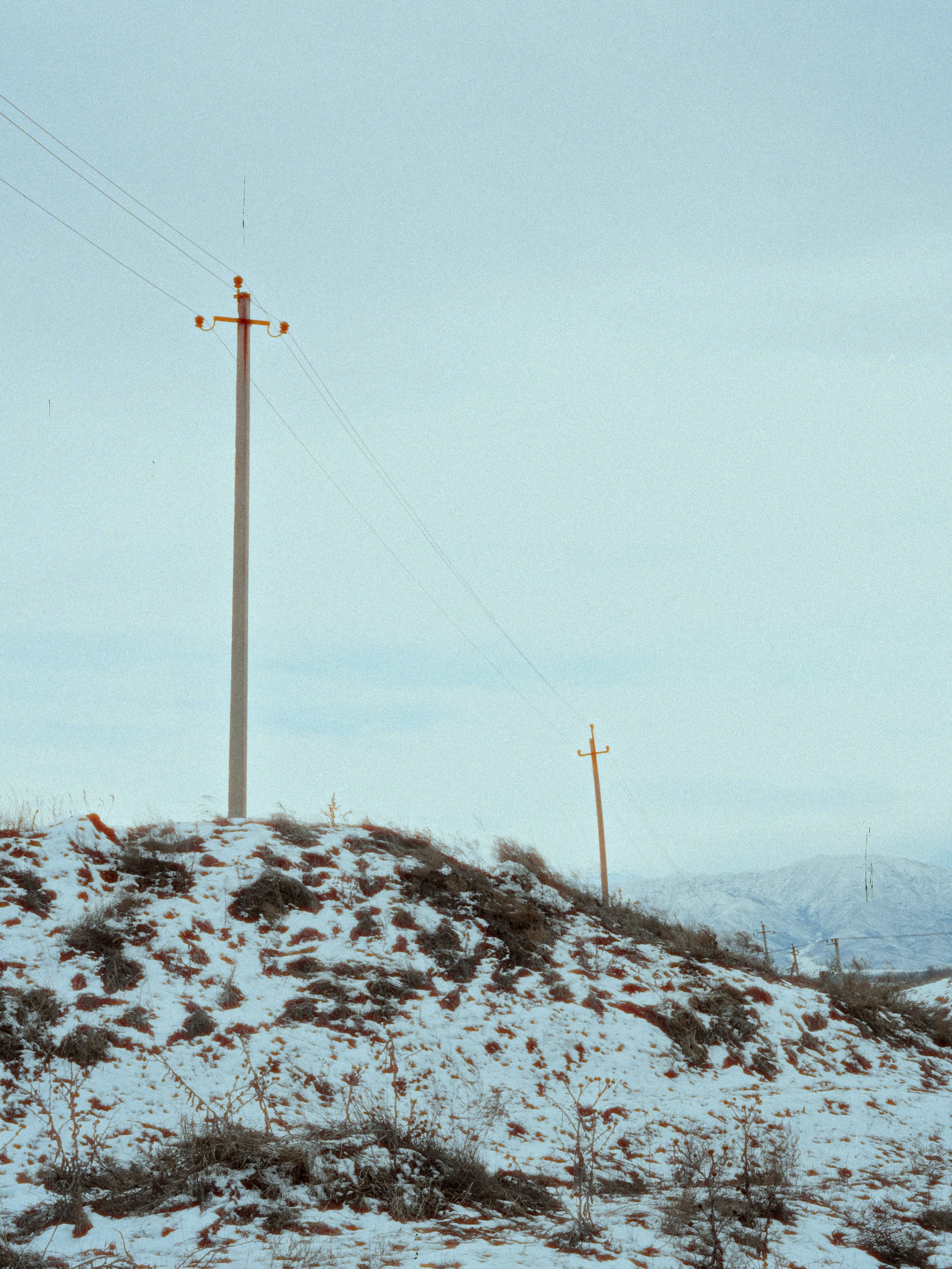 Snowy Substation Ridge: Power Lines Quietly Crossing a Winter Plain