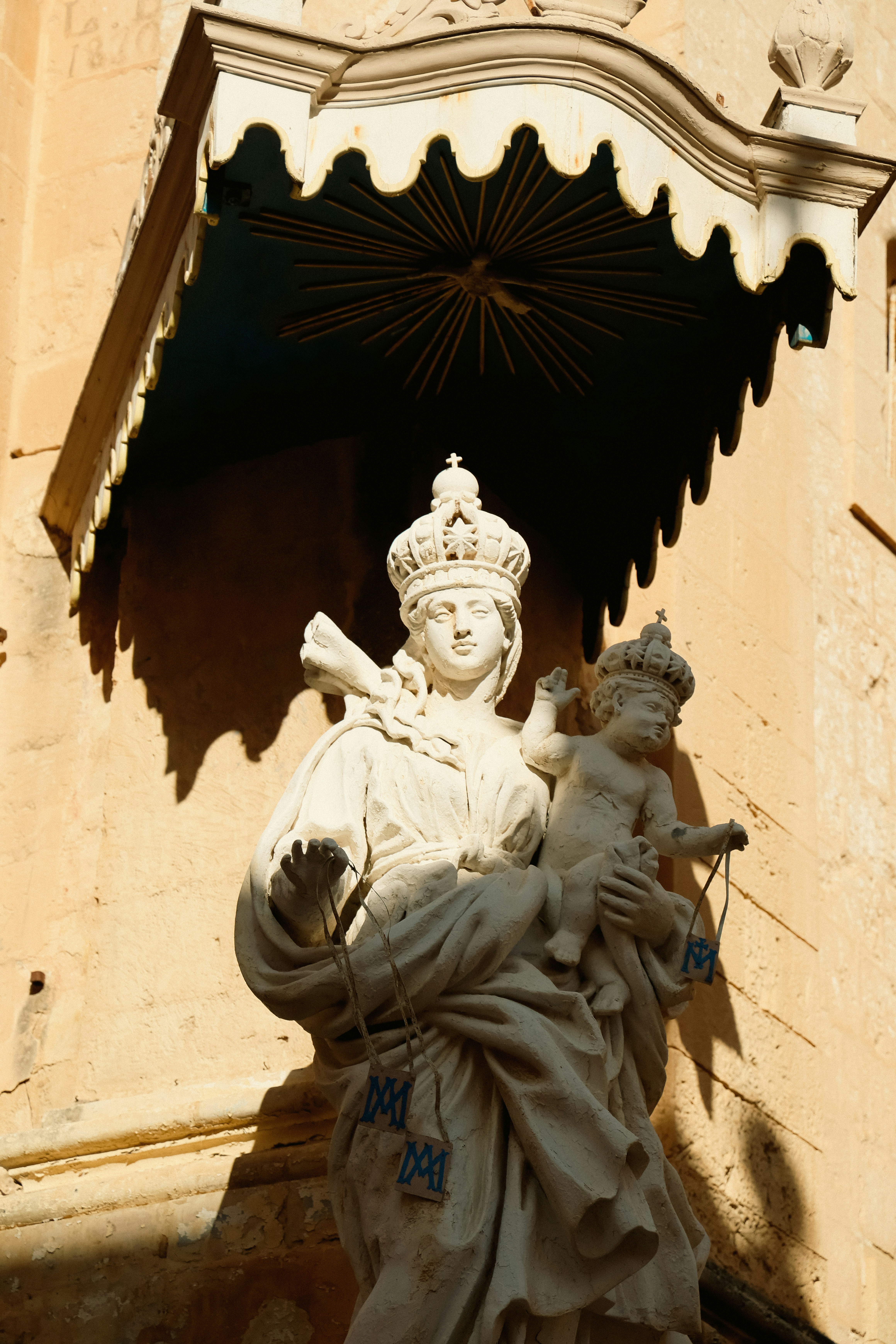 Marble statue of madonna and child with crowns.