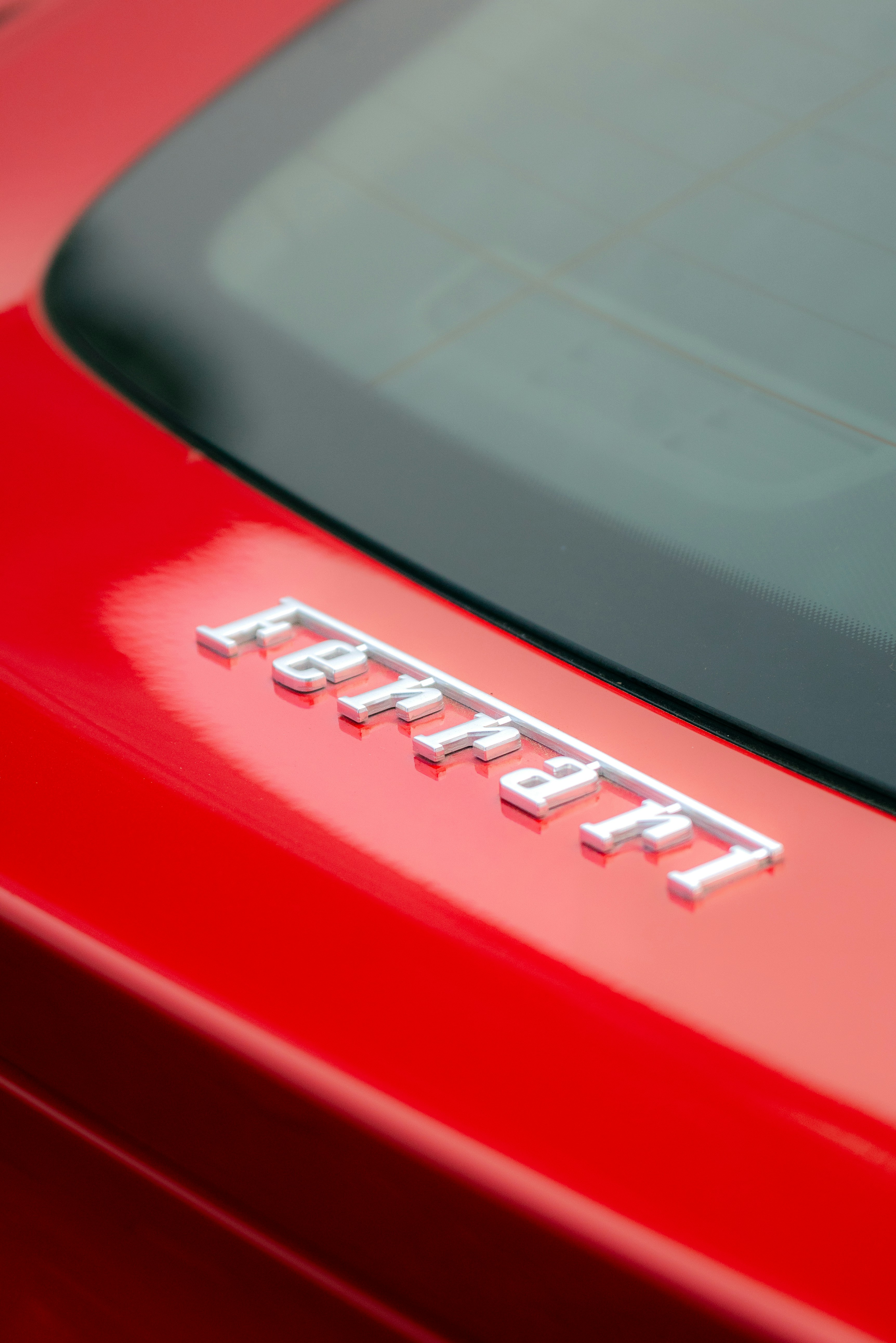 Shiny Ferrari Emblem: A Glinting Moment on Red Curves