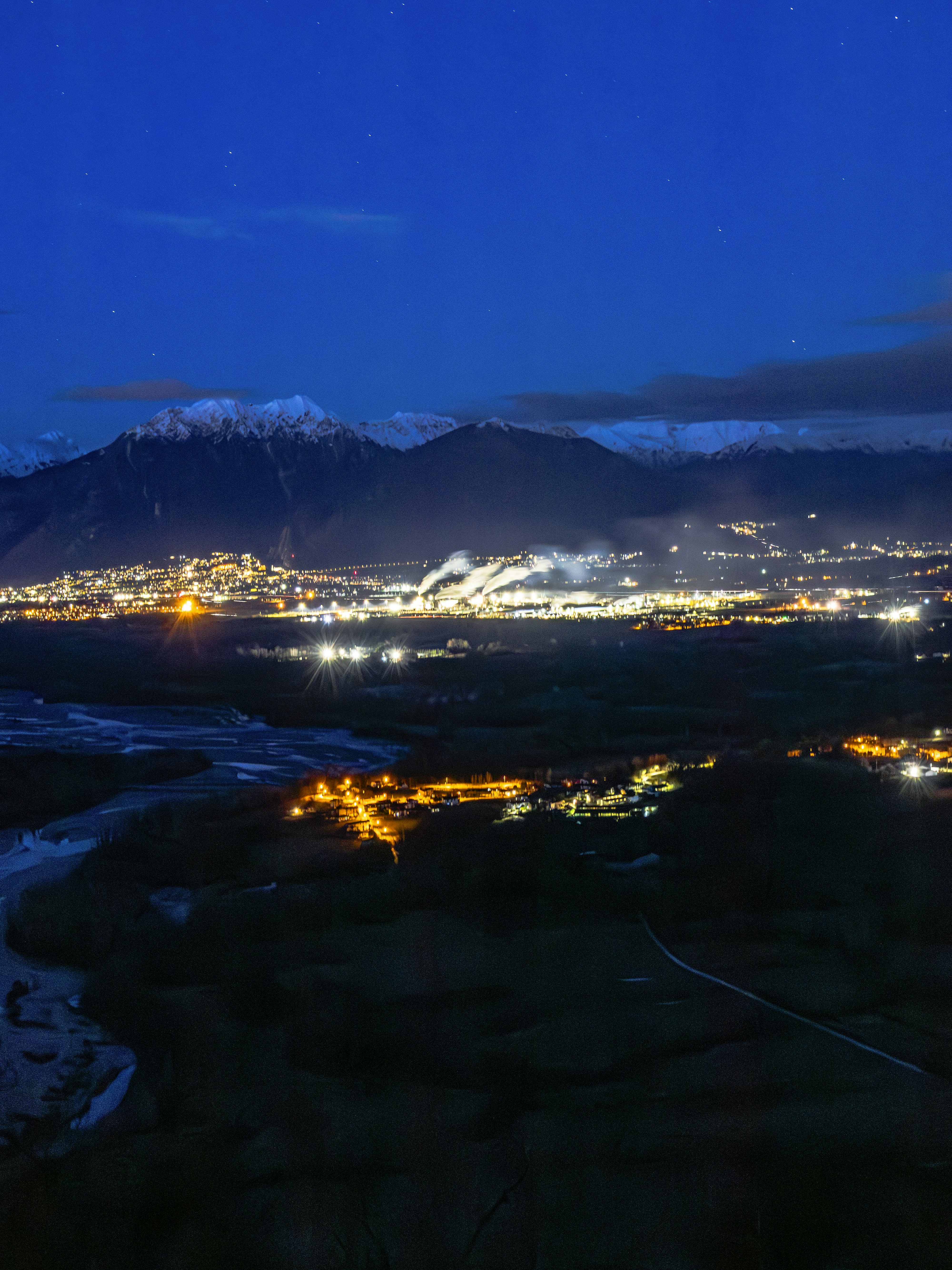 Nightfall Over a Town at the Foot of Snowy Peaks