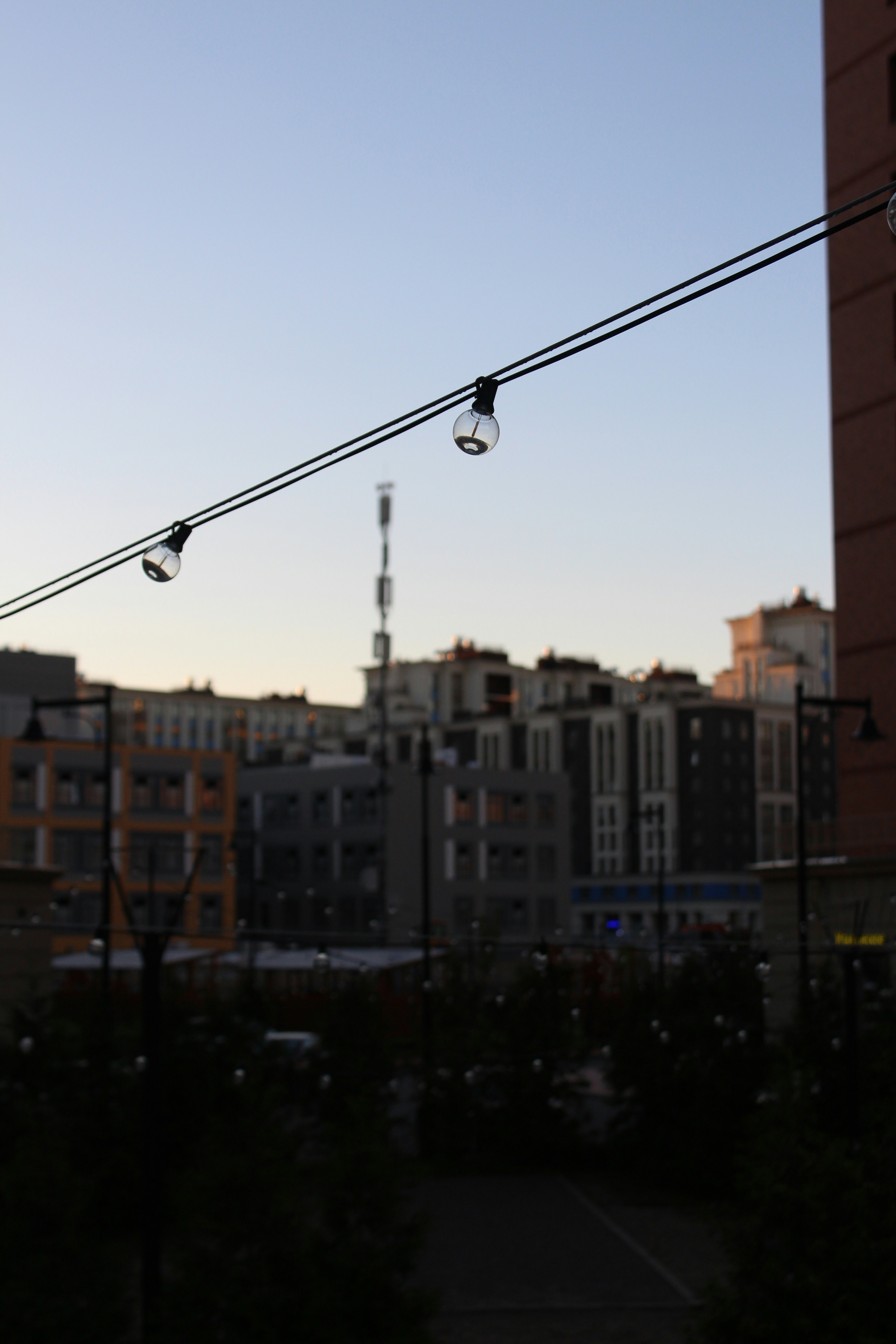 Urban string lights over a quiet morning terrace