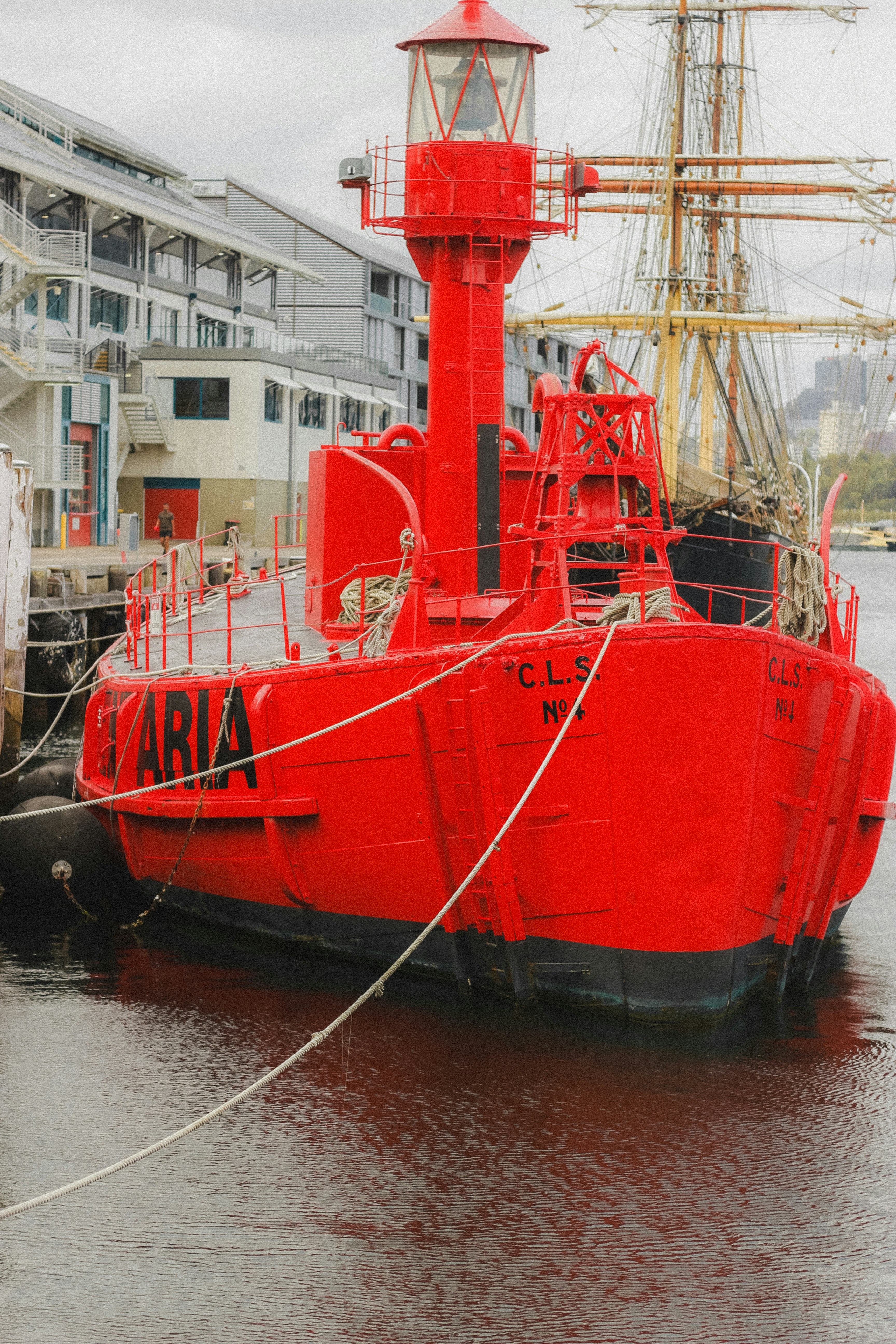Crimson Tug: A Red Vessel Docked by Industrial Wharves