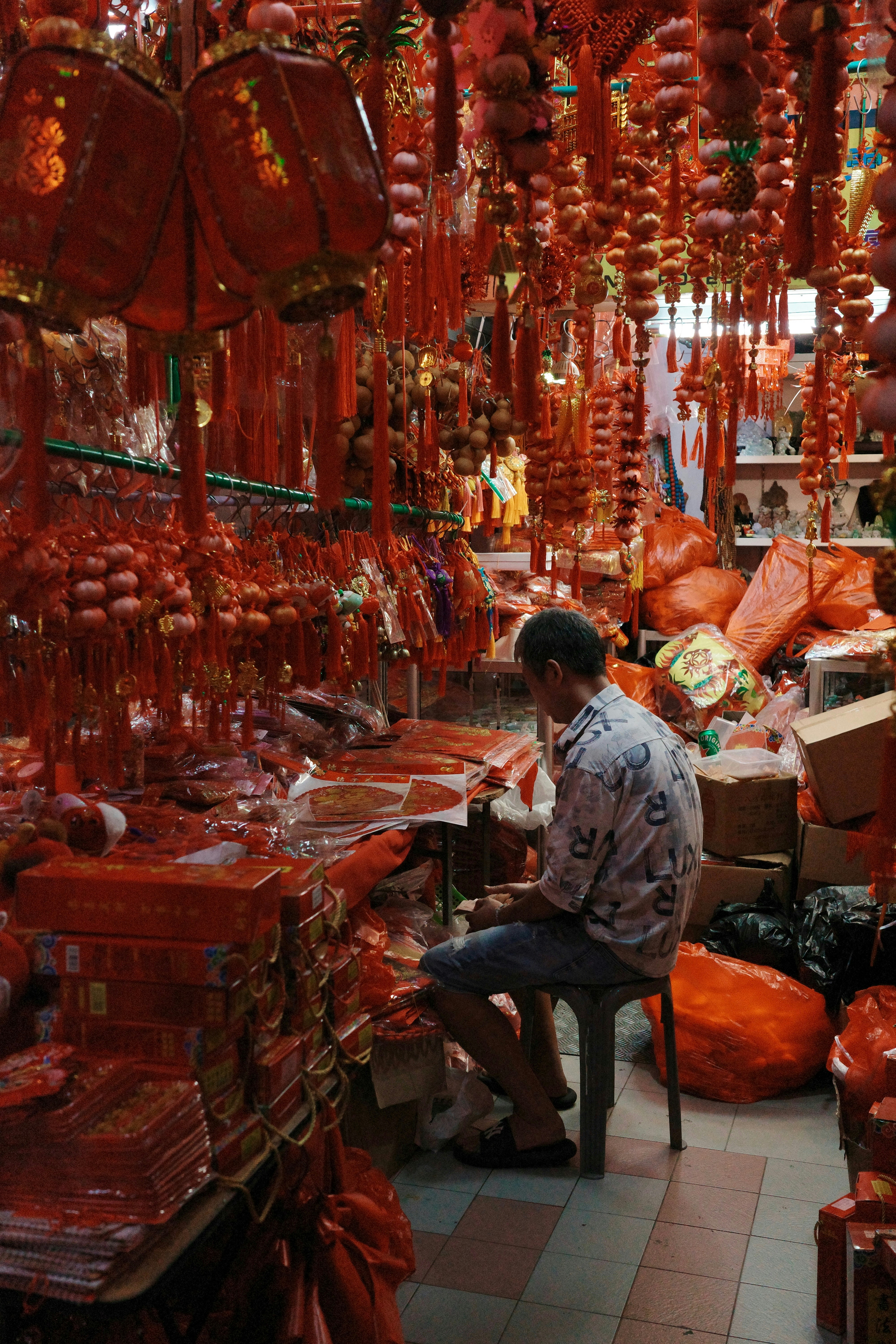 Market Oddities: A Man Among Red Ornaments