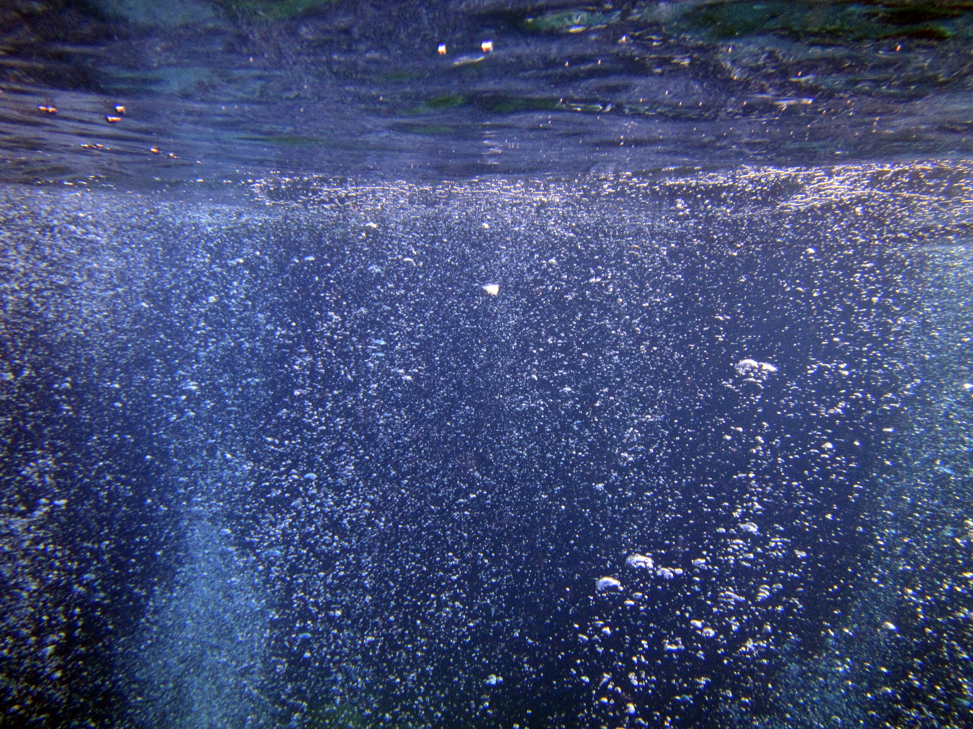 Bubbles rising in deep blue water