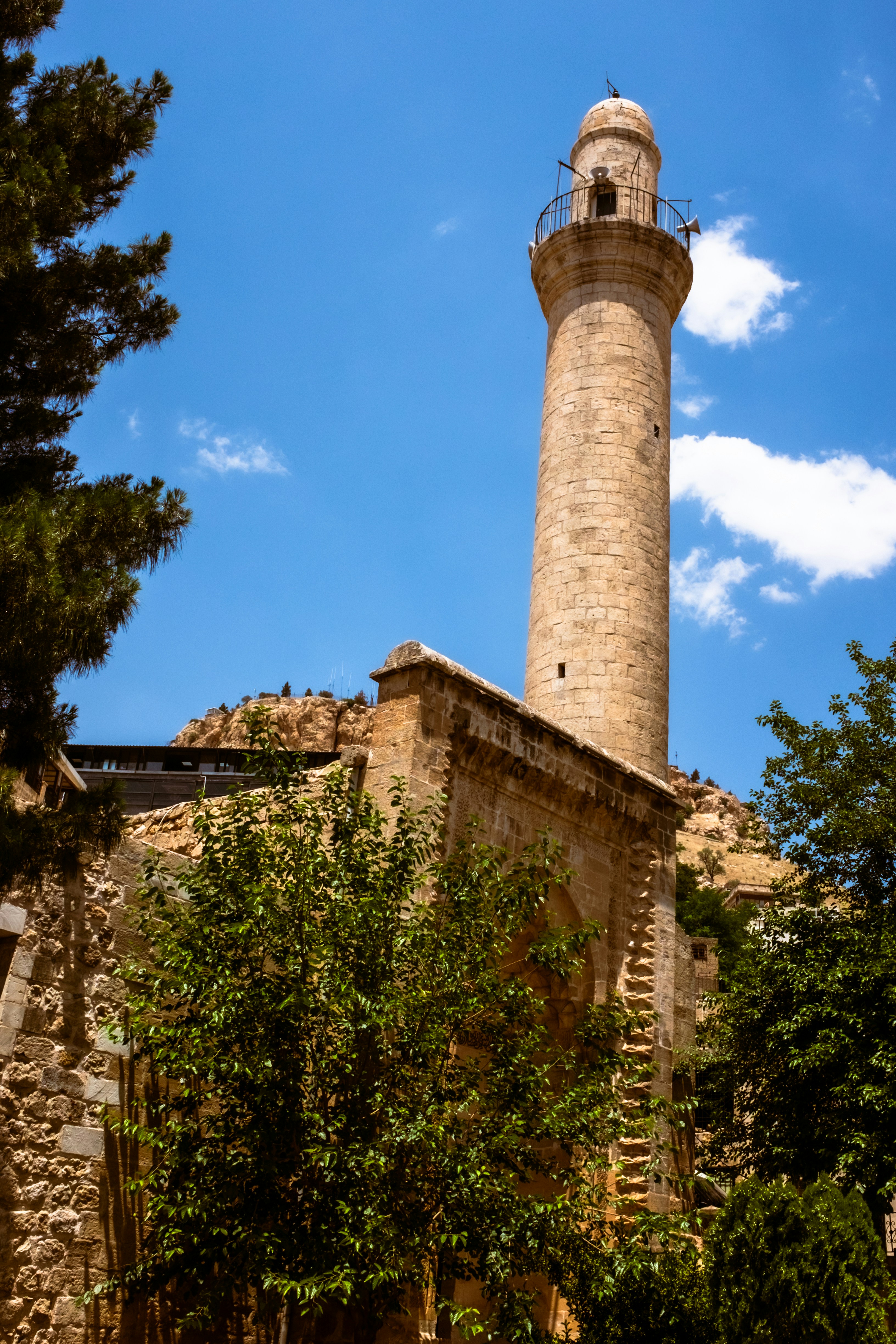 Lighthouse Rising Above Ancient Stonework Under a Bright Blue Sky