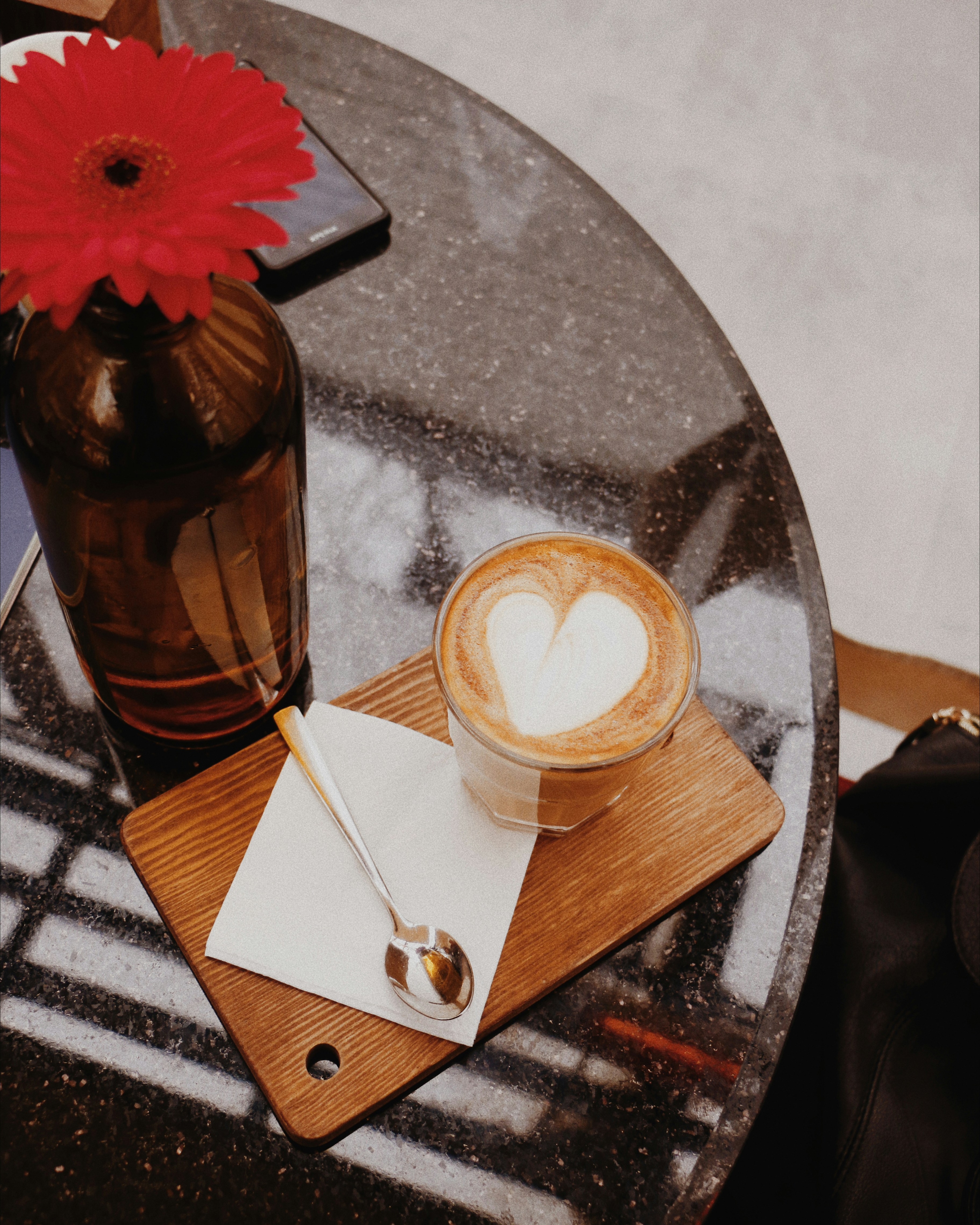 A Latte and a Red Bloom: Quiet Café Moment on a Glass Table