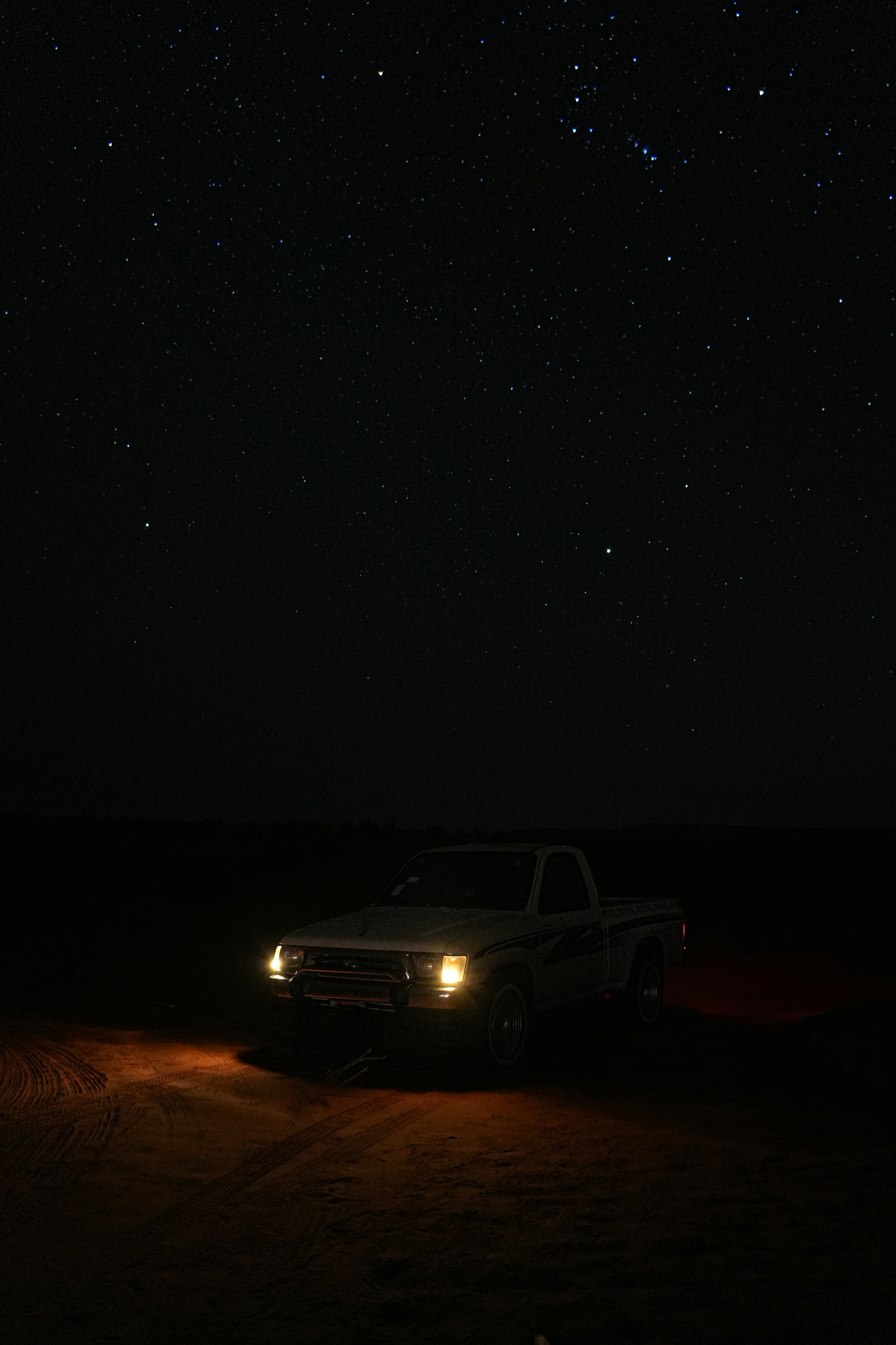 Starlit Pickup: A Lone Vehicle Beneath a Velvet Night Sky