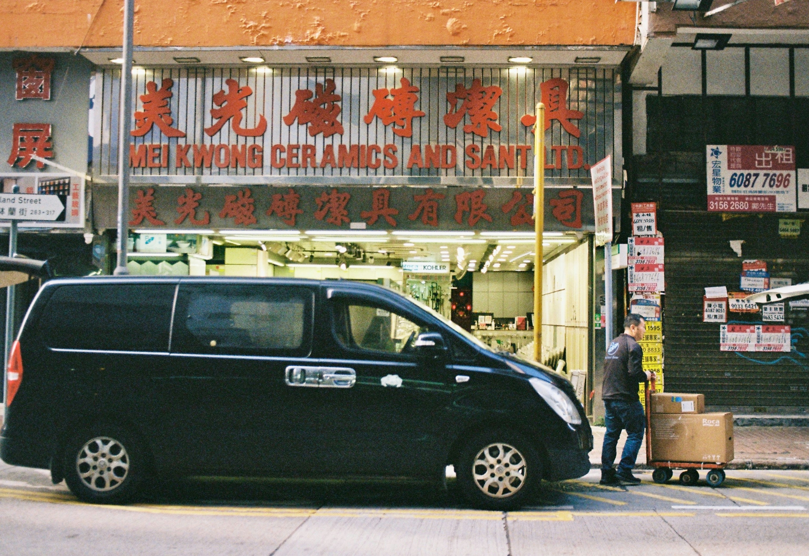 Urban Transfer: A Black Van Pauses Before a Cantonese storefront