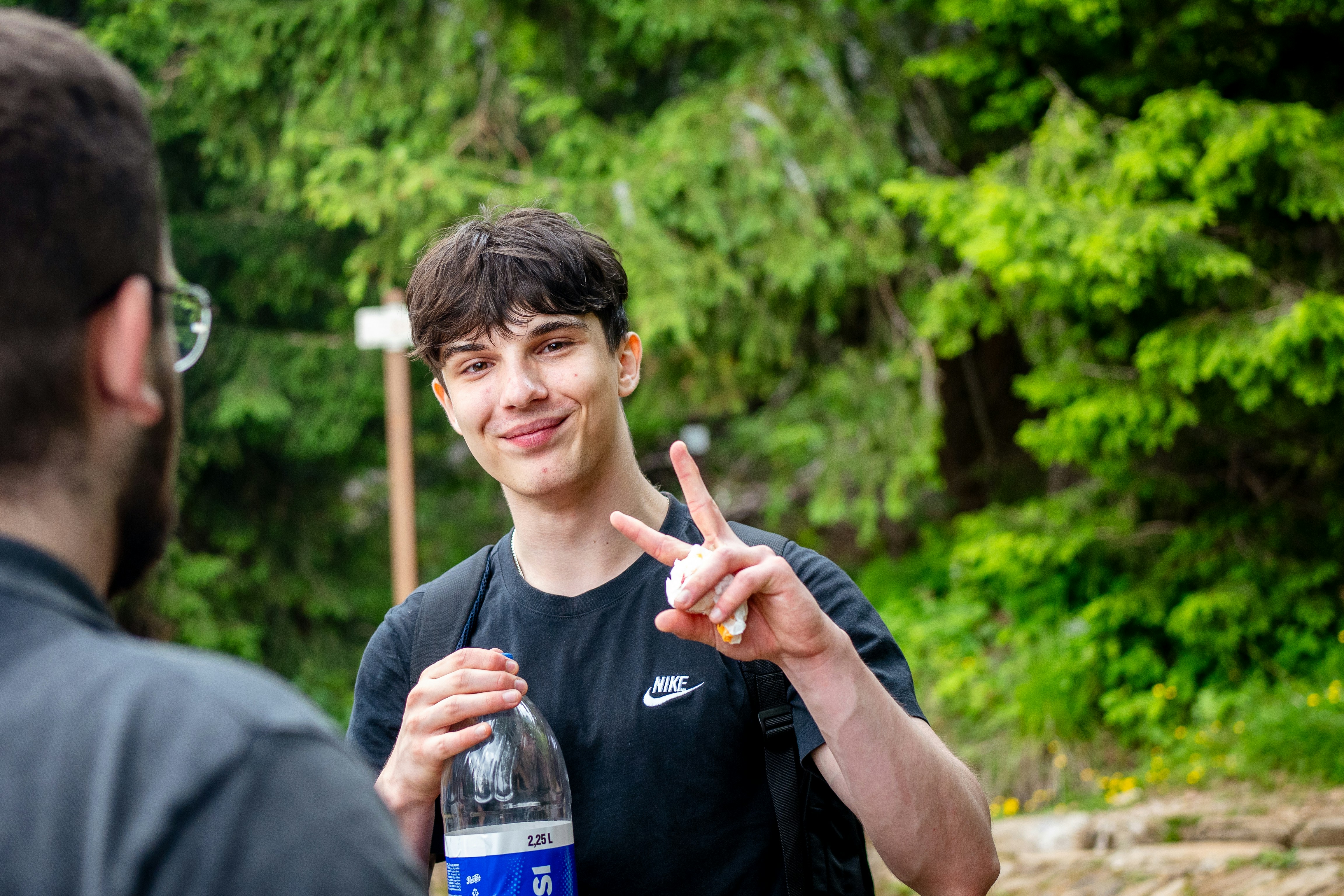 Smile and Peace Sign: A Friendly Outdoor Moment