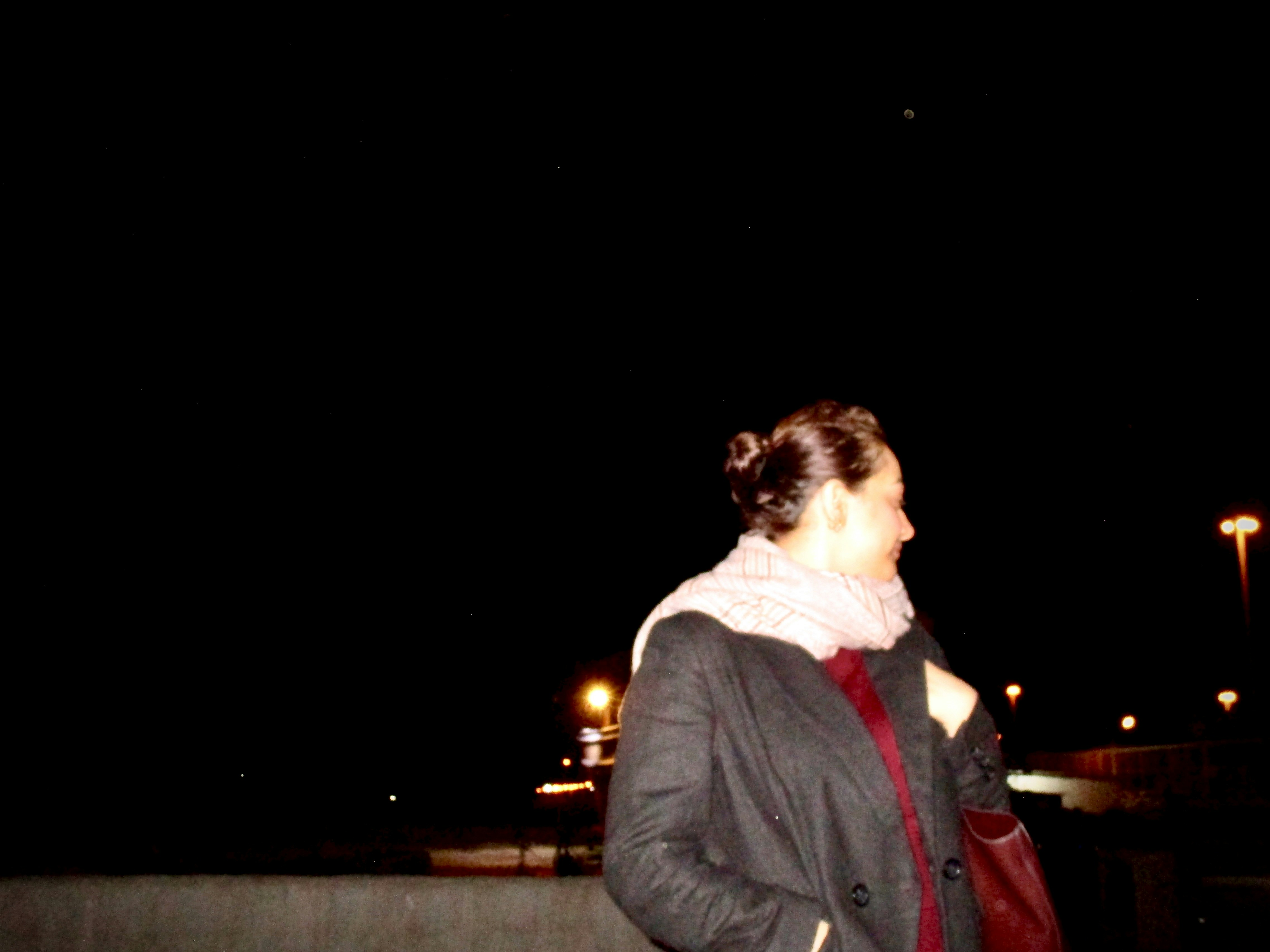 Woman looking away at night with city lights