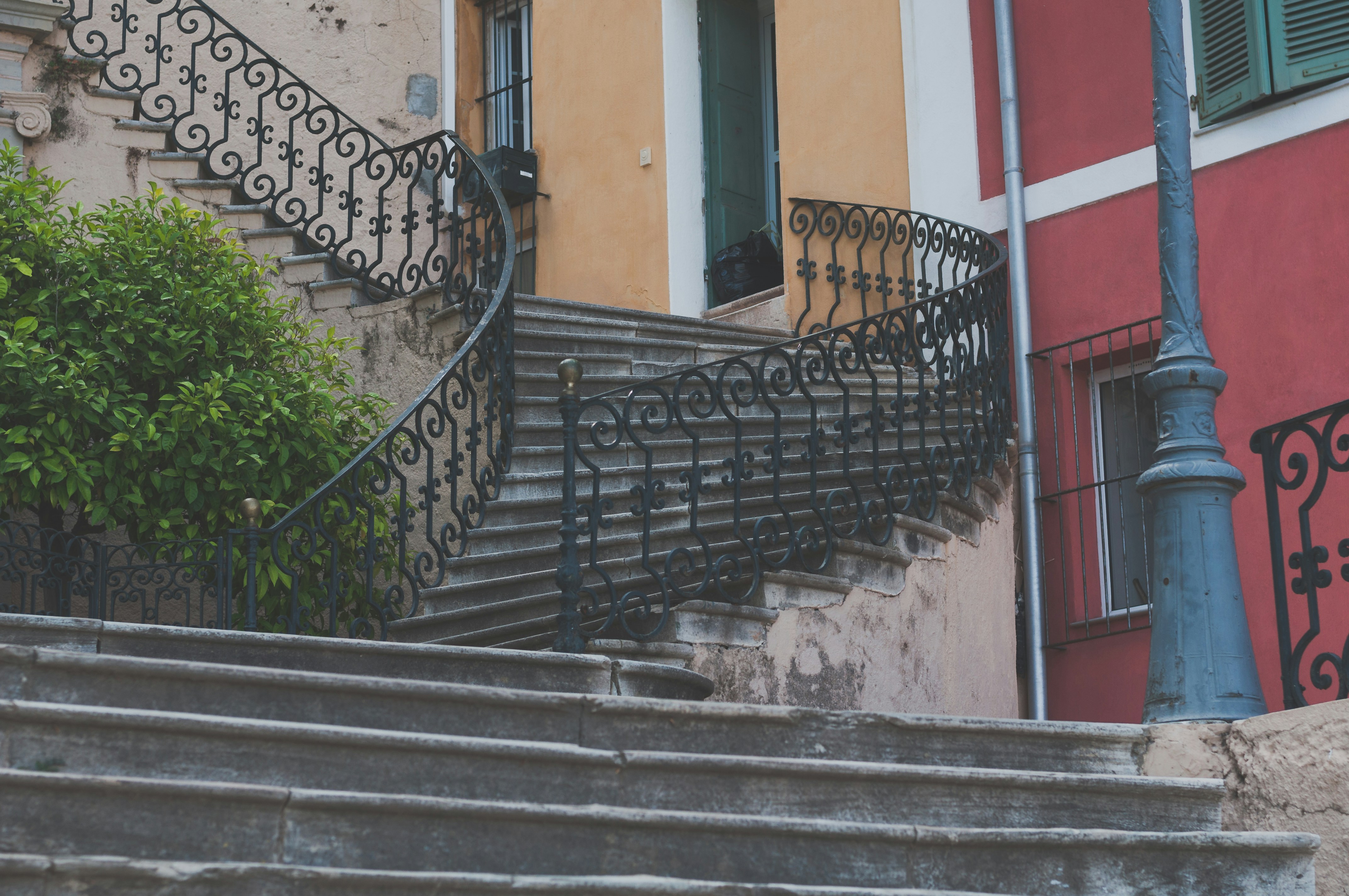 Wrought Iron Staircase Weave Against Painted Facades