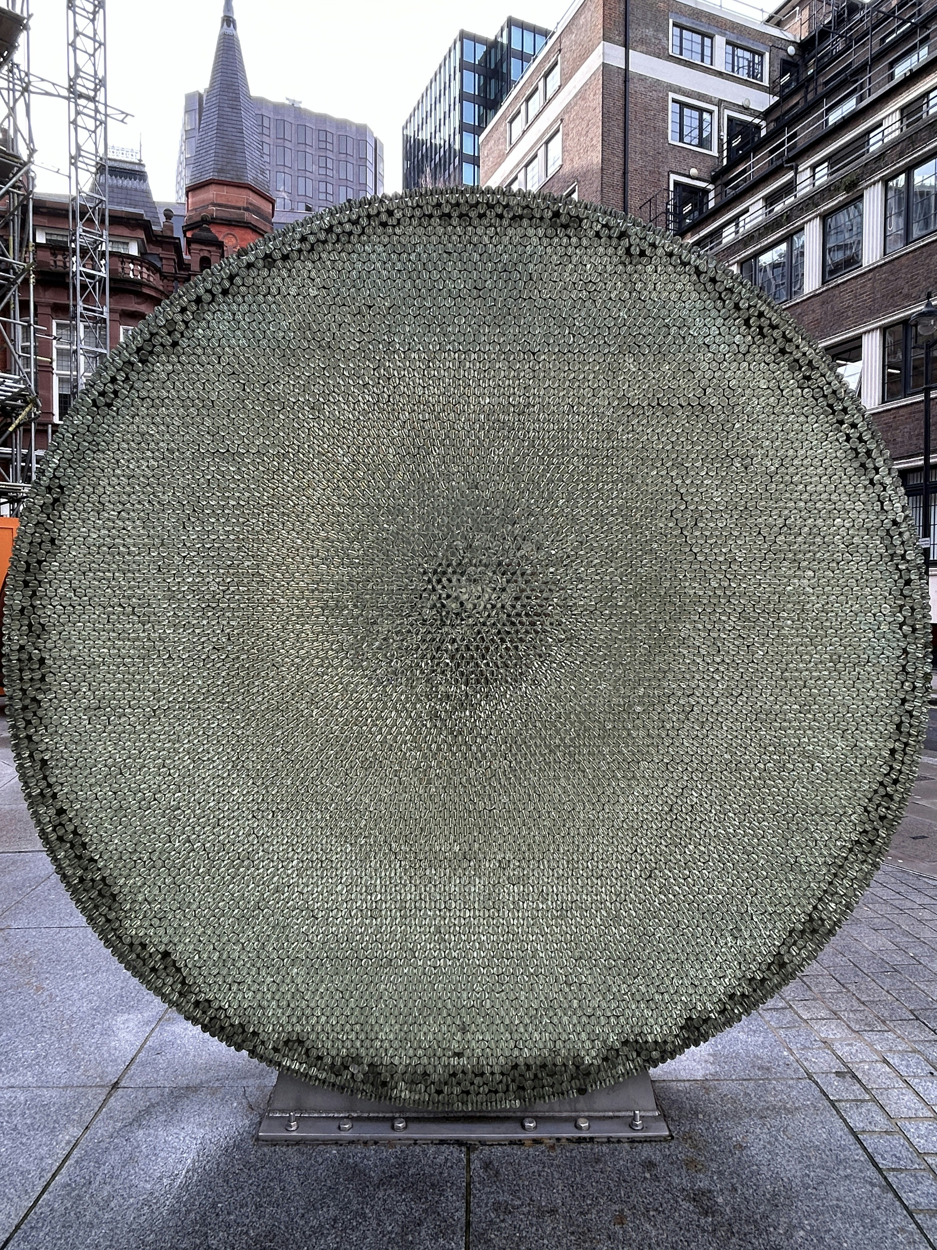 Circular Sculpture in an Urban Gallery of Glass and Brick