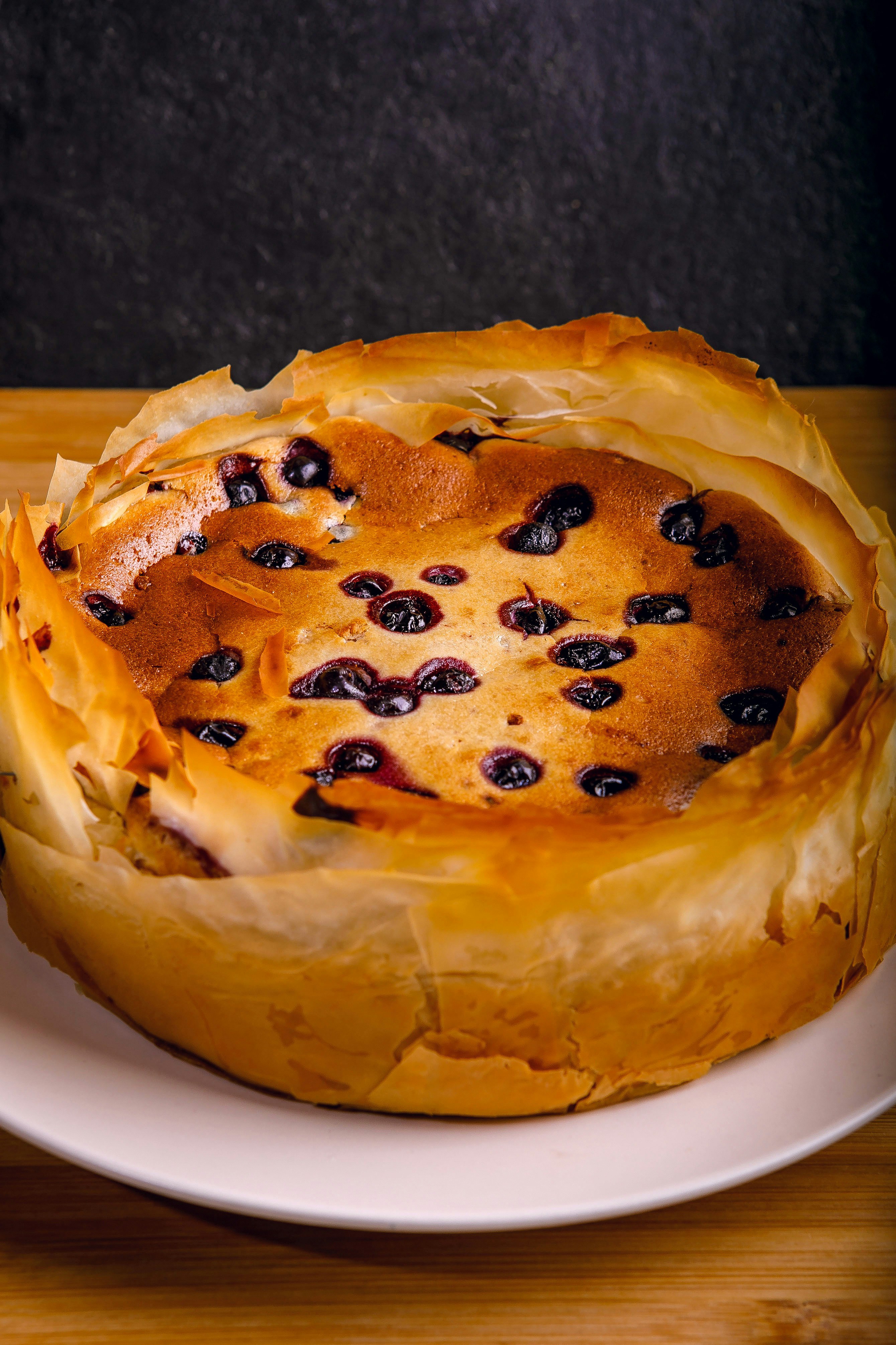 Golden-Rimmed Berry Bustle: A Rustic Cherry-Blueberry Cheesecake Emerges from Crunchy Phyllo