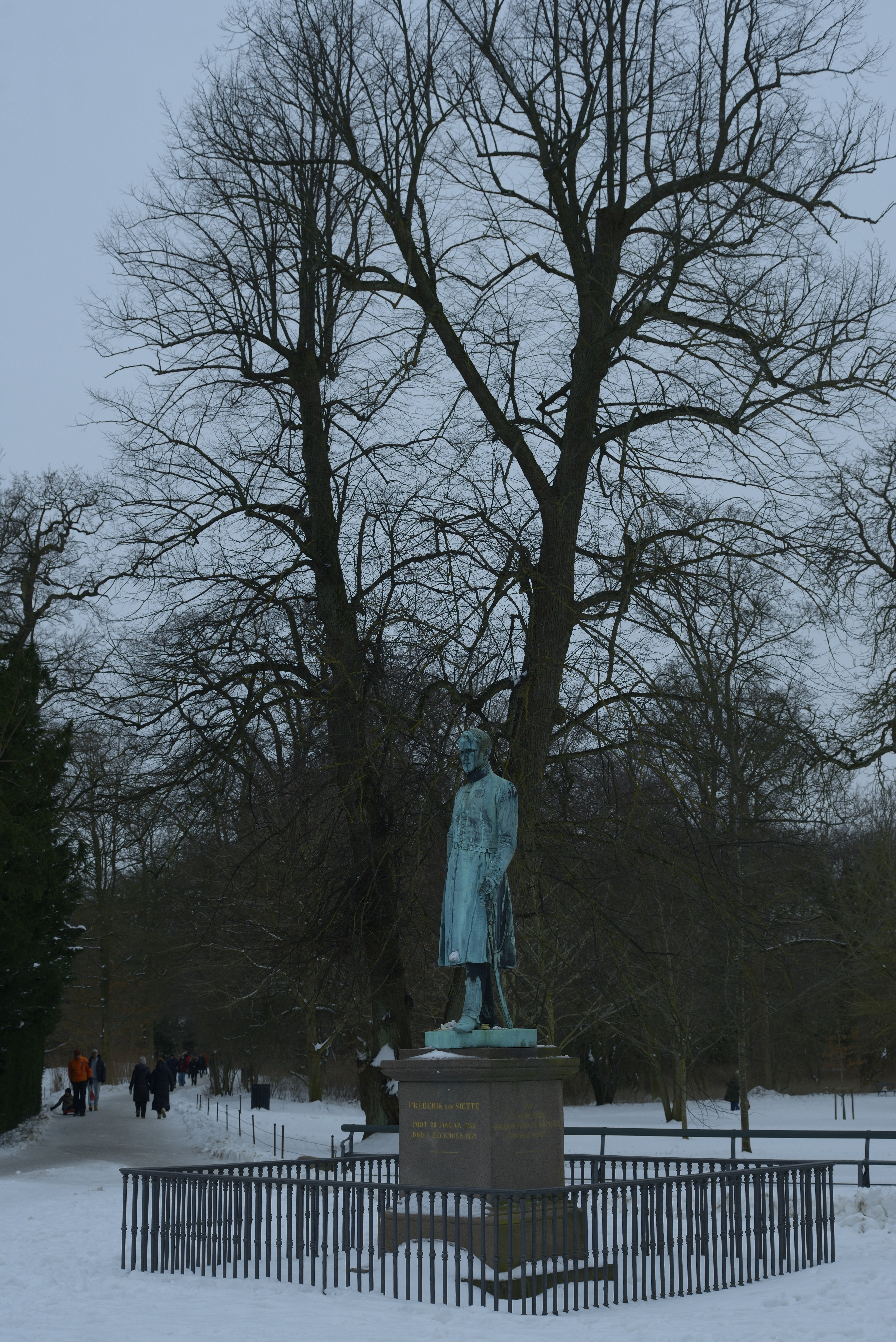 Statue in a Winter Park: Frozen Grandeur Beneath Bare Trees