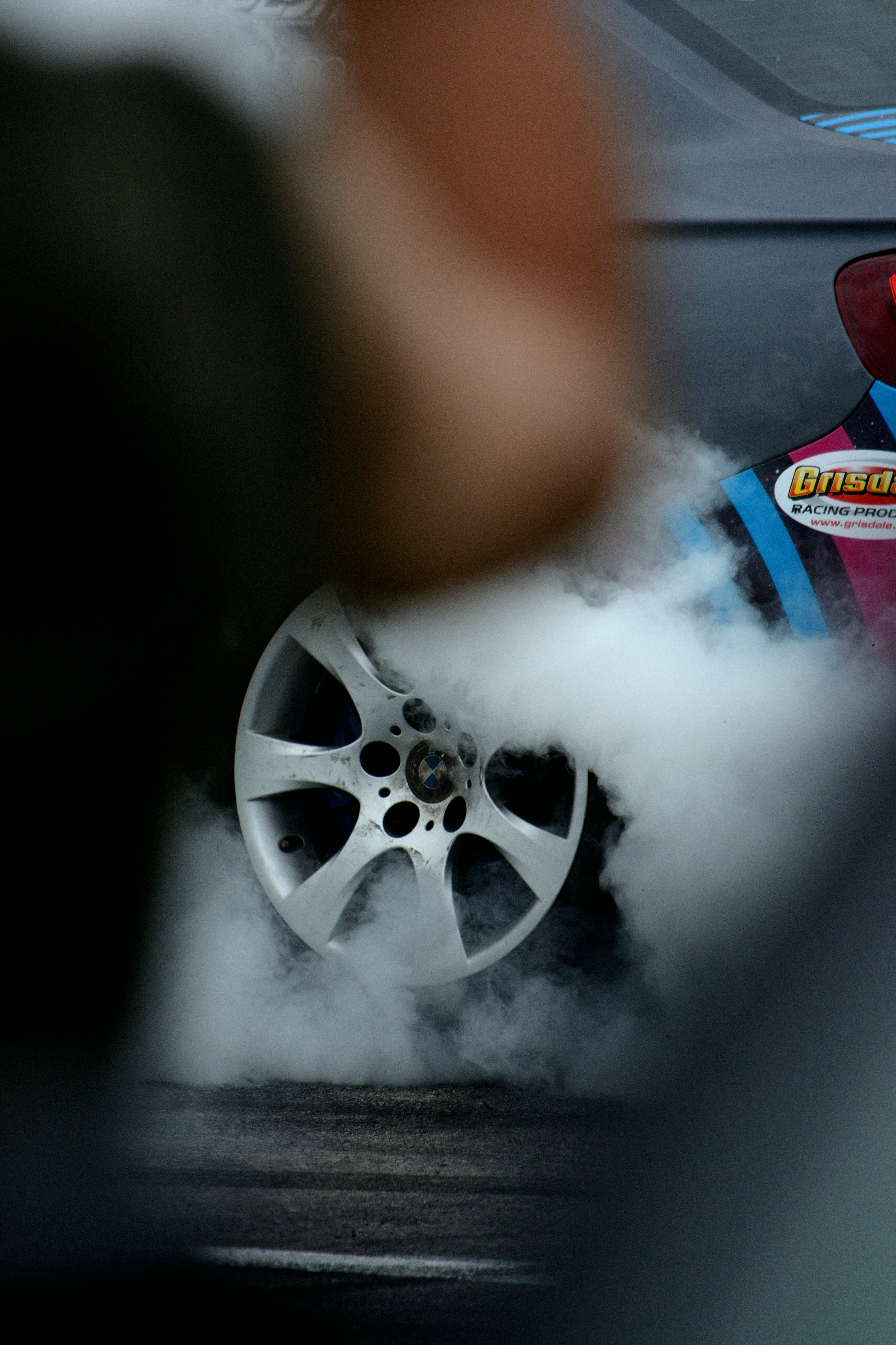 Steamy wheels: a drifting tire illuminated by exhaust smoke