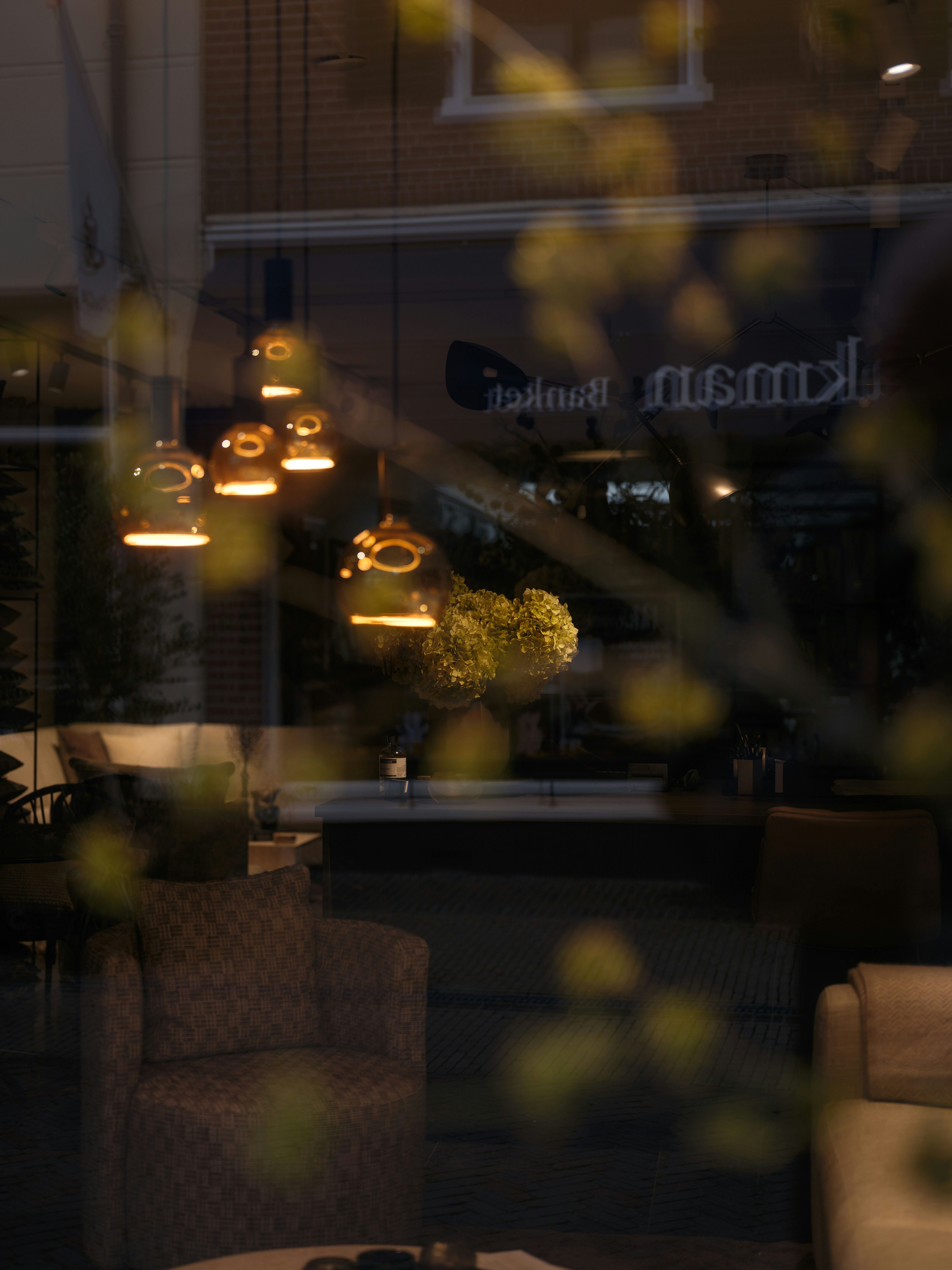 Warm glow through a dimly lit lounge: blurred foregrounds, sharp candle-like lamps