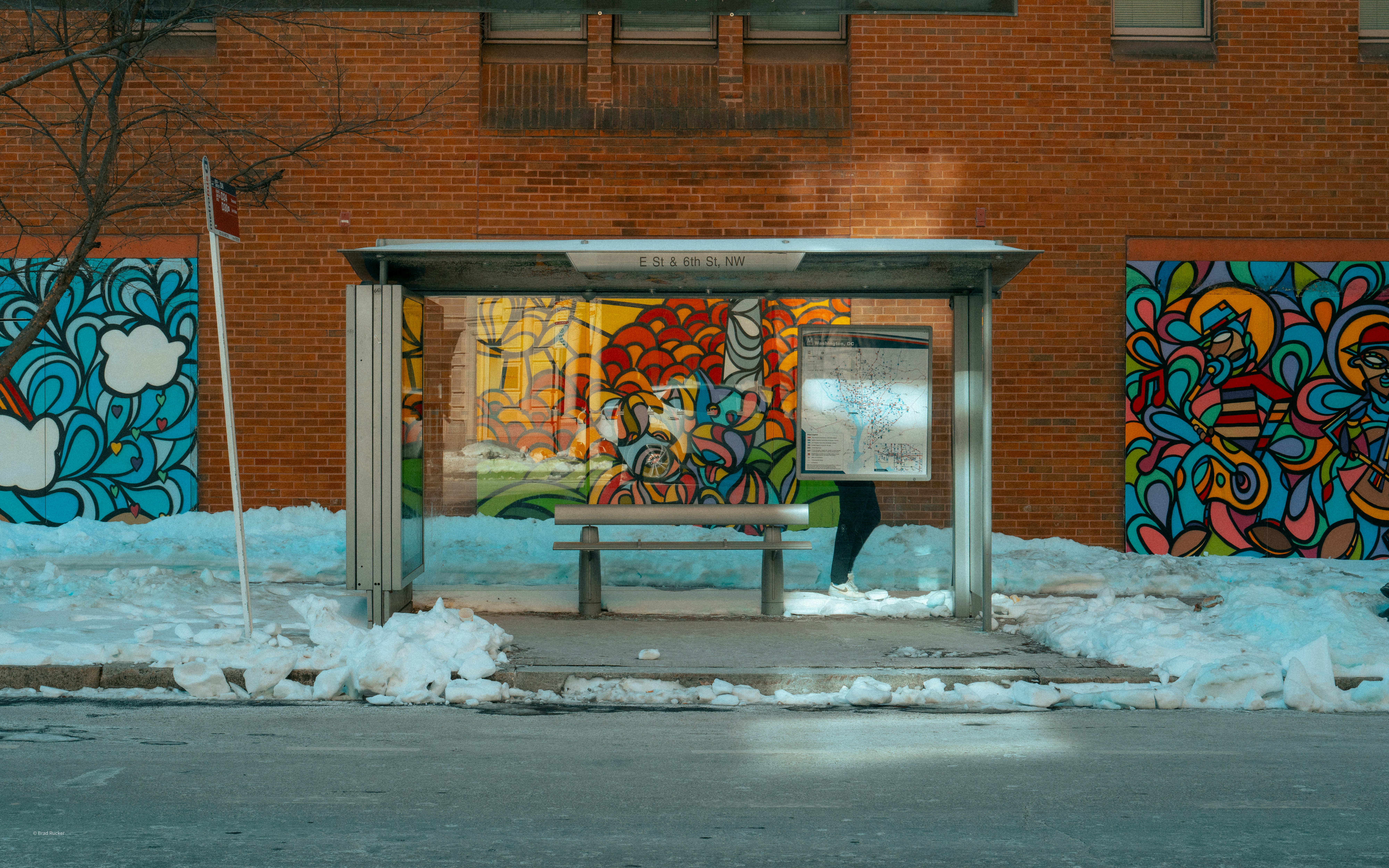 Colorful mural bus stop amid winter residue