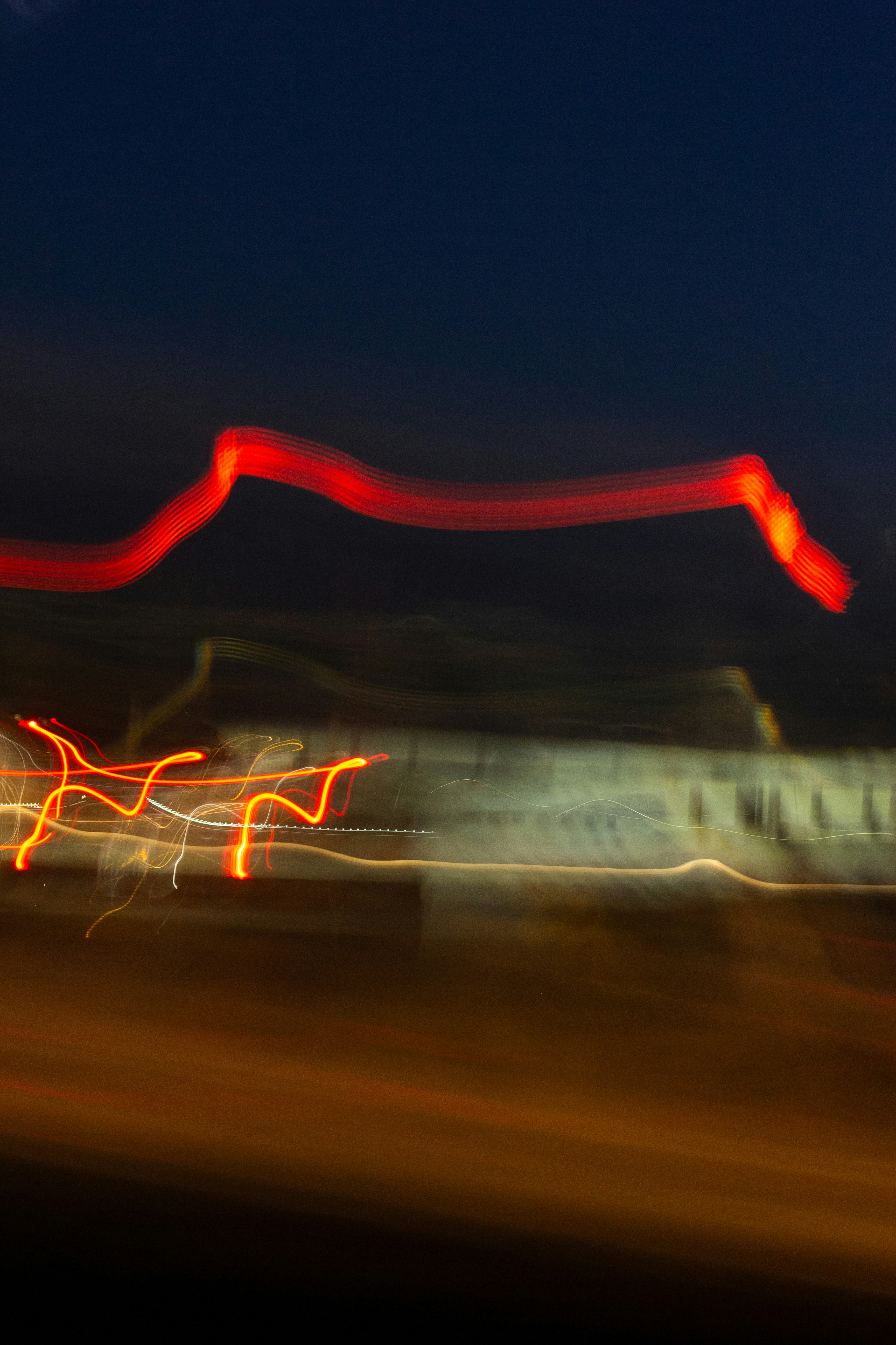 Night Run of Light Trails Across a Quiet Street