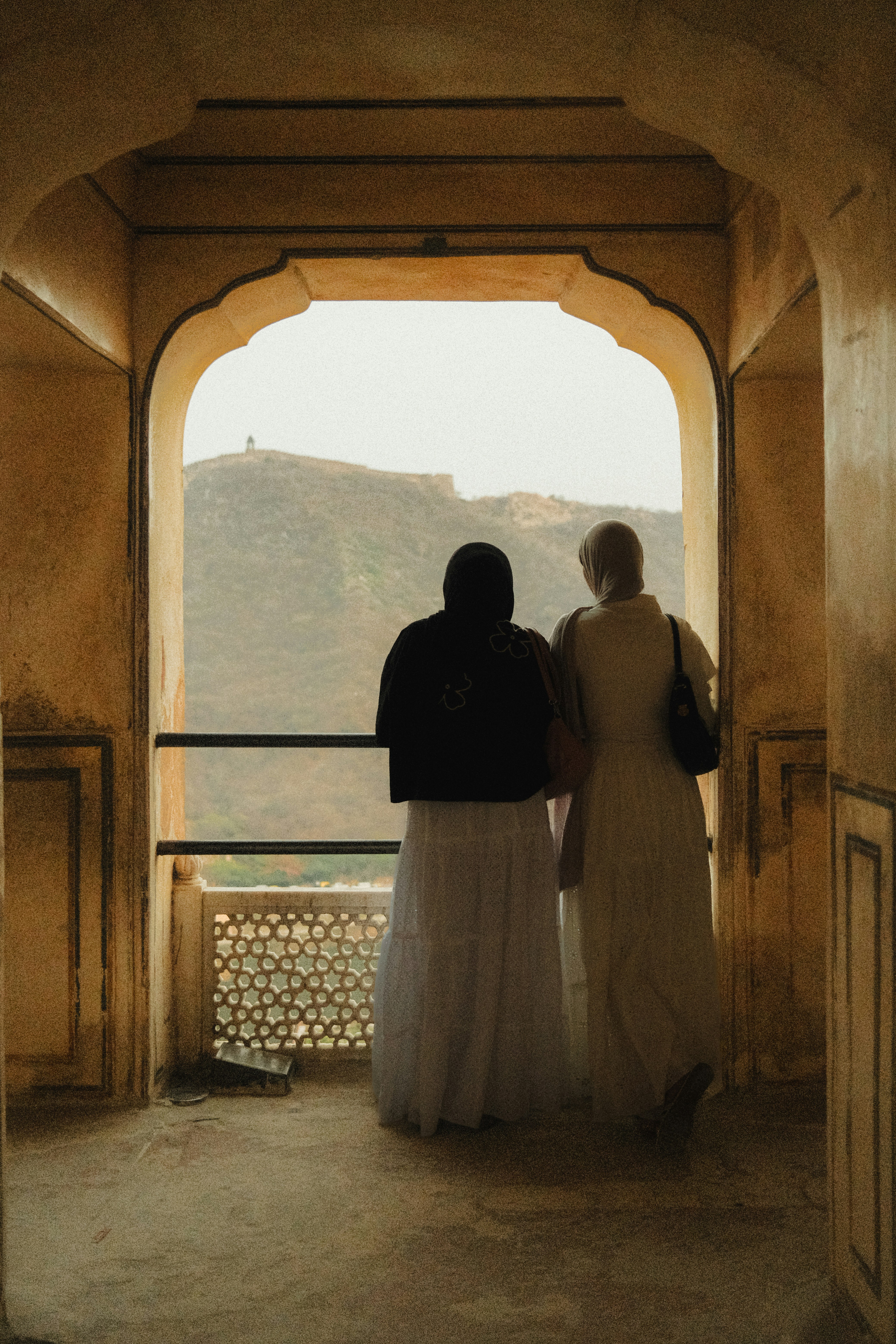 Twin Silhouettes at the Archway: Quiet Moment in a Himalayan Vista