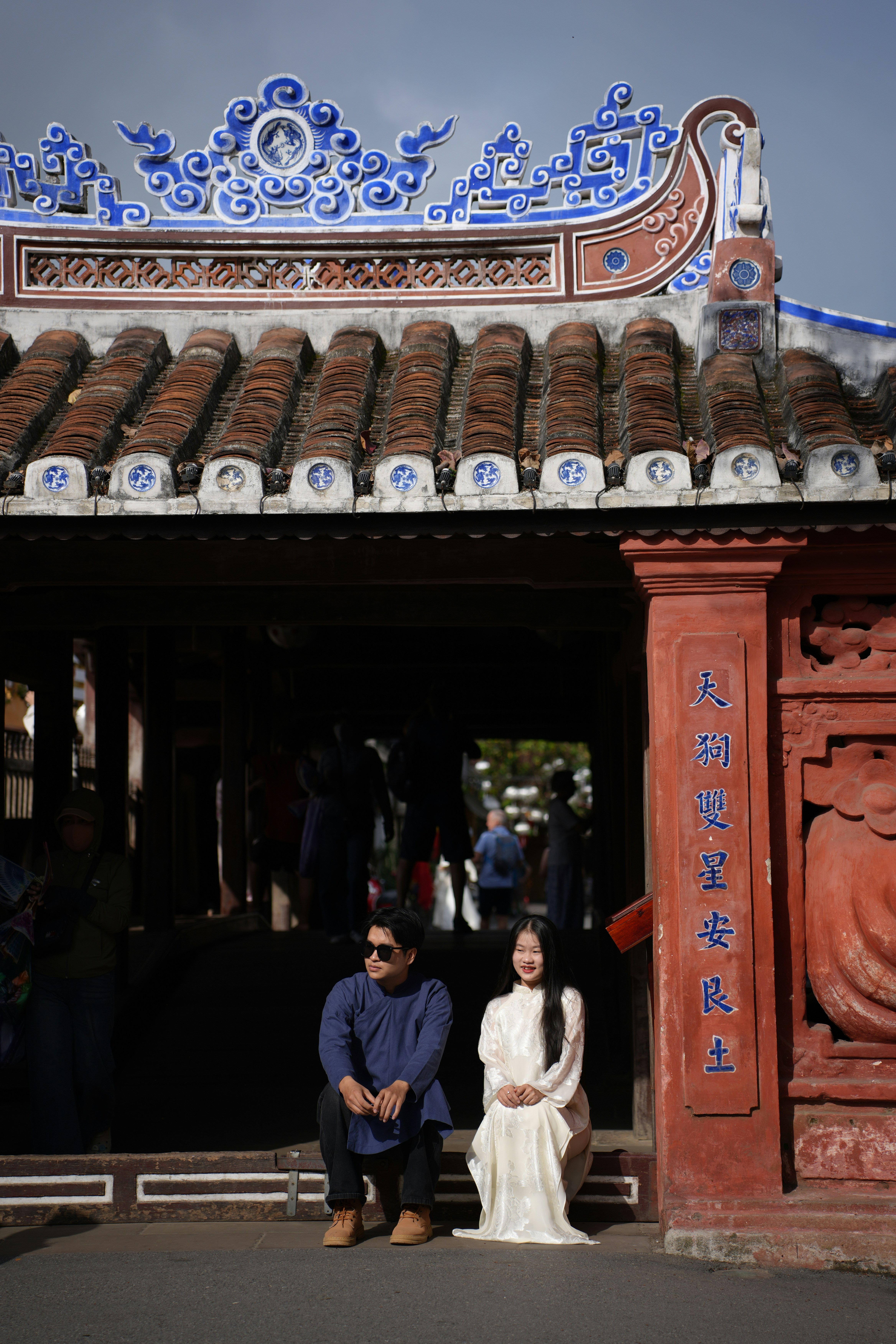 Two Visitors in a Lacquered Archway: Quiet Pause at a Traditional Gate
