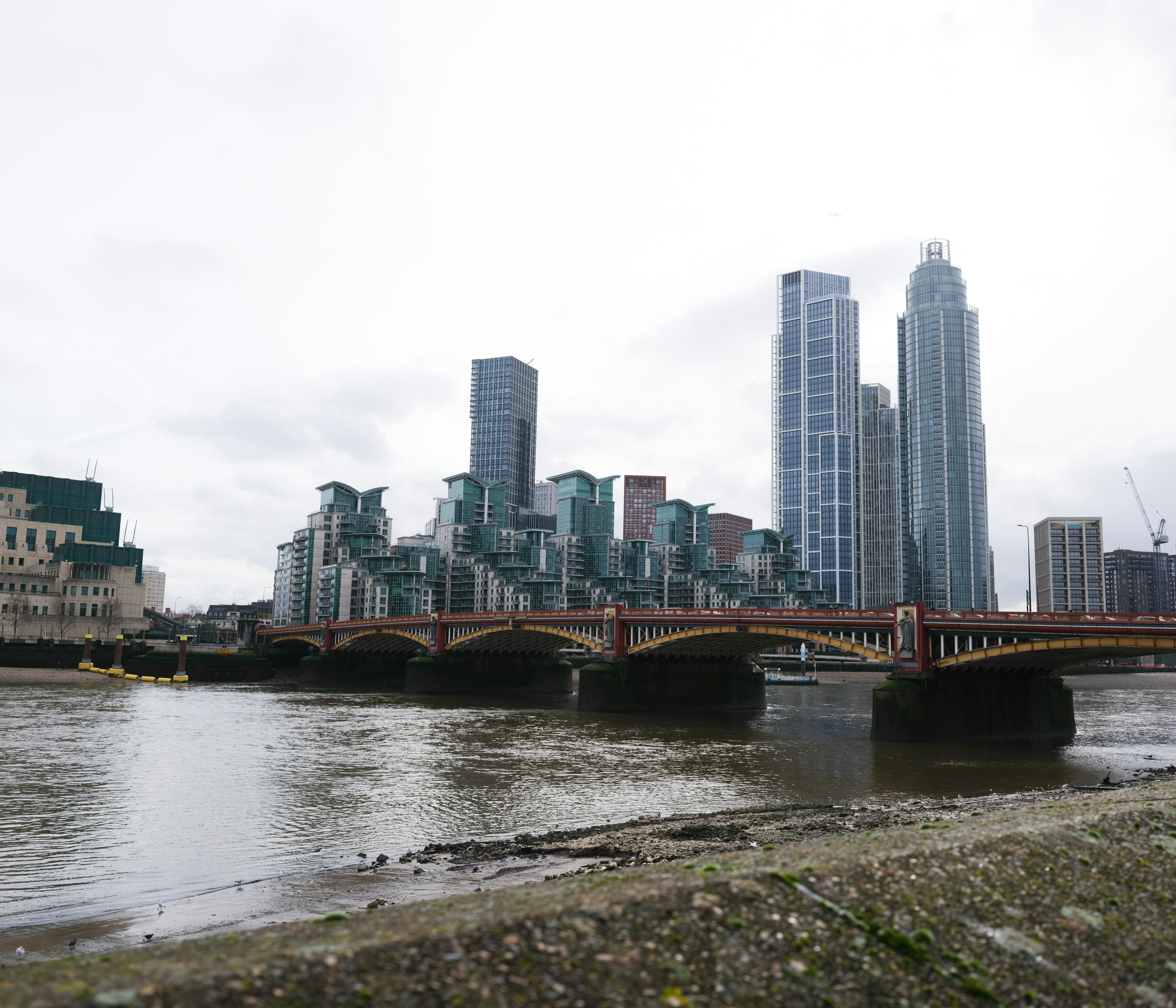 Brick arches and steel skyline over a quiet river