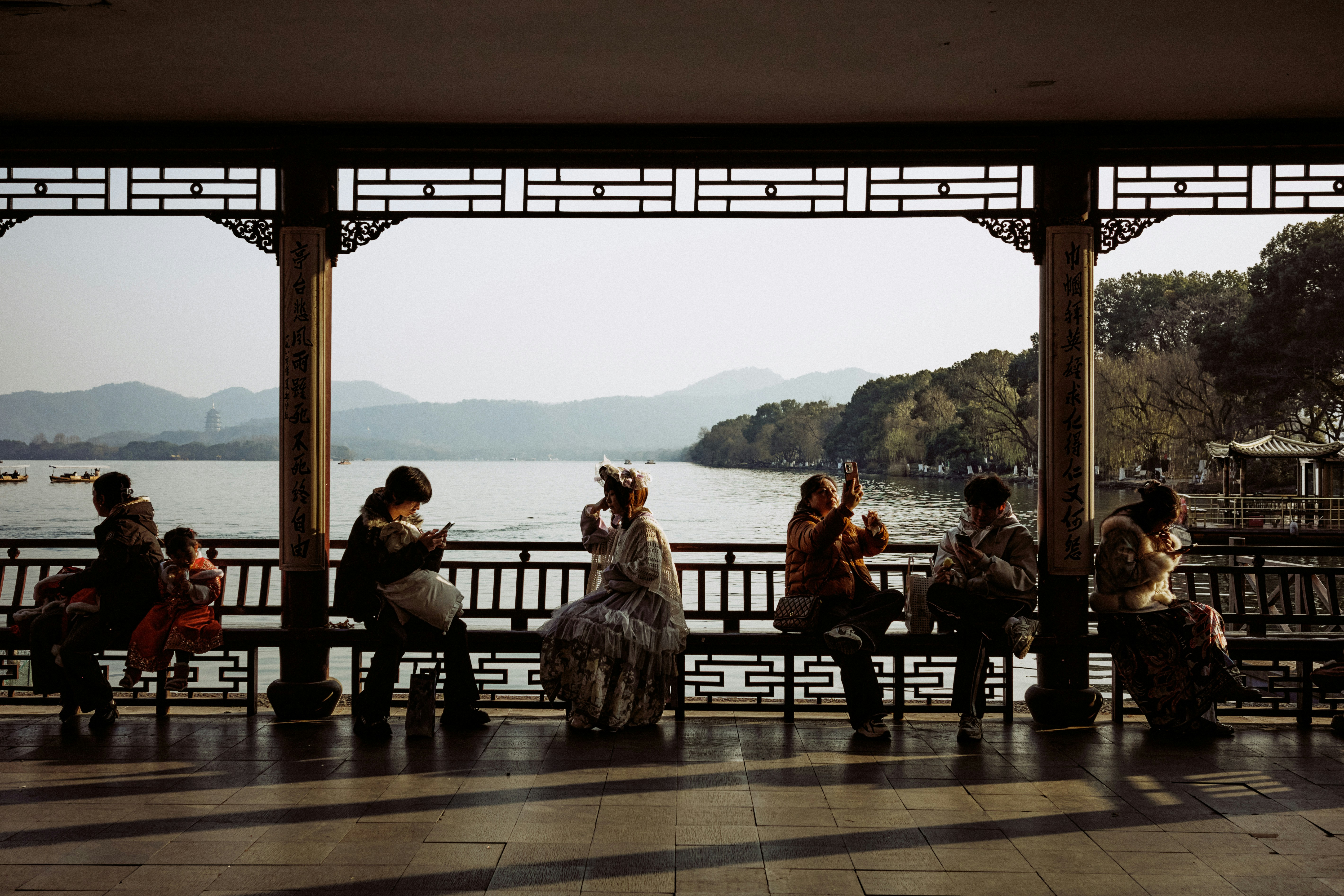 Quiet Portraits on the Pavilion: Faces Silhouetted Against a Lake