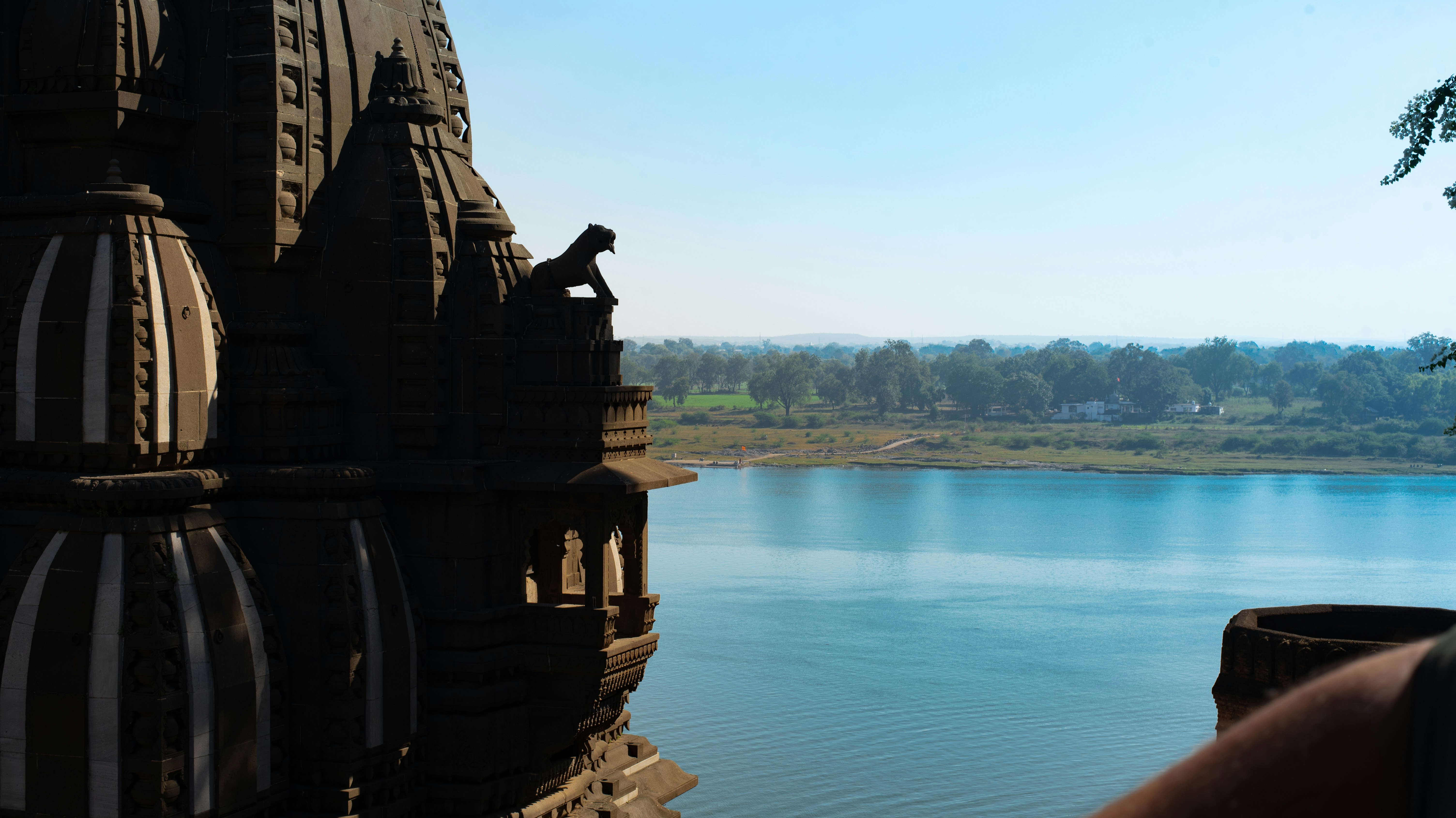 Riverside Silhouette: Ancient Temple Framing the Quiet Blue