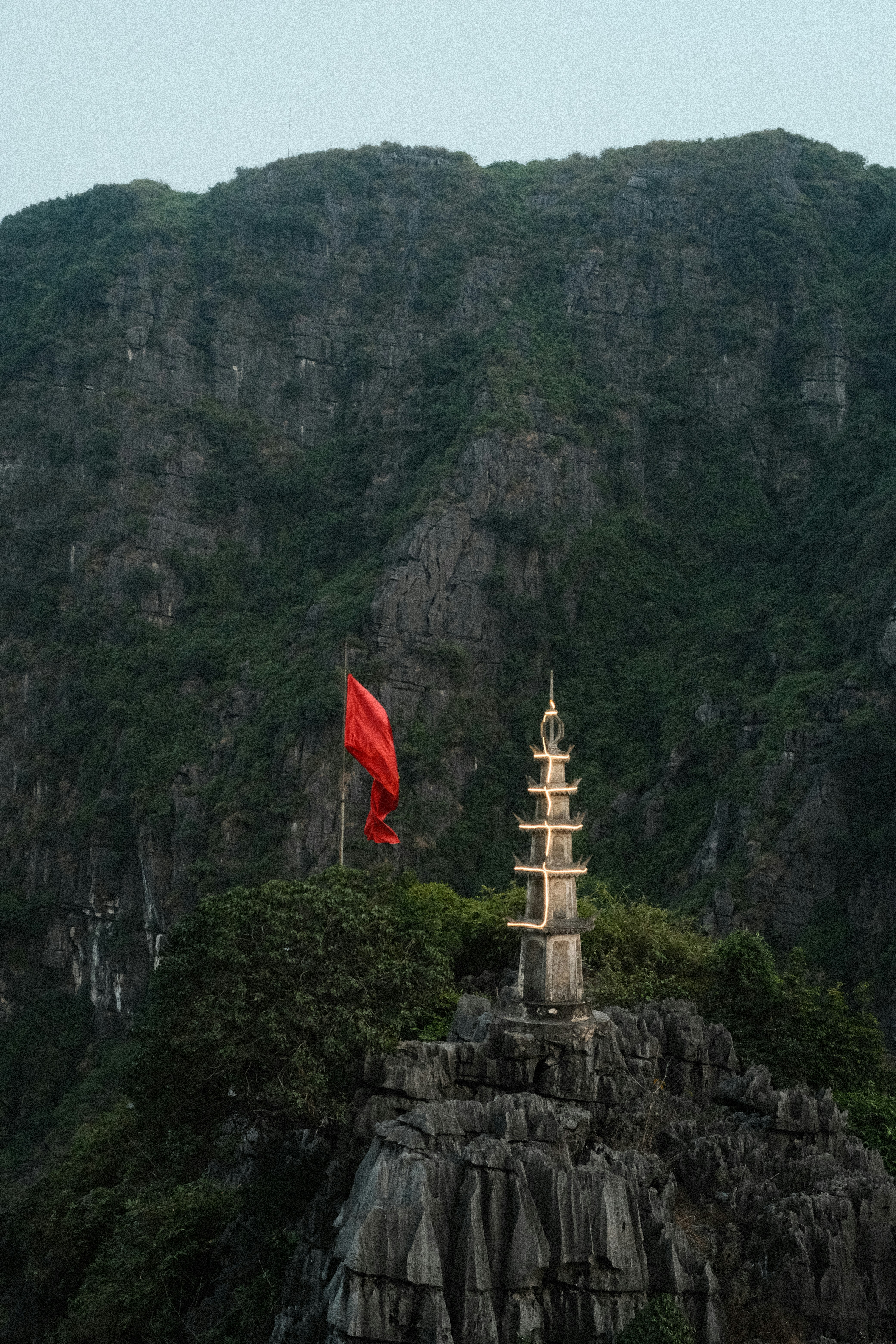 Red Flag on Stone Spire: A Quiet Moment Between Mountain and Monument