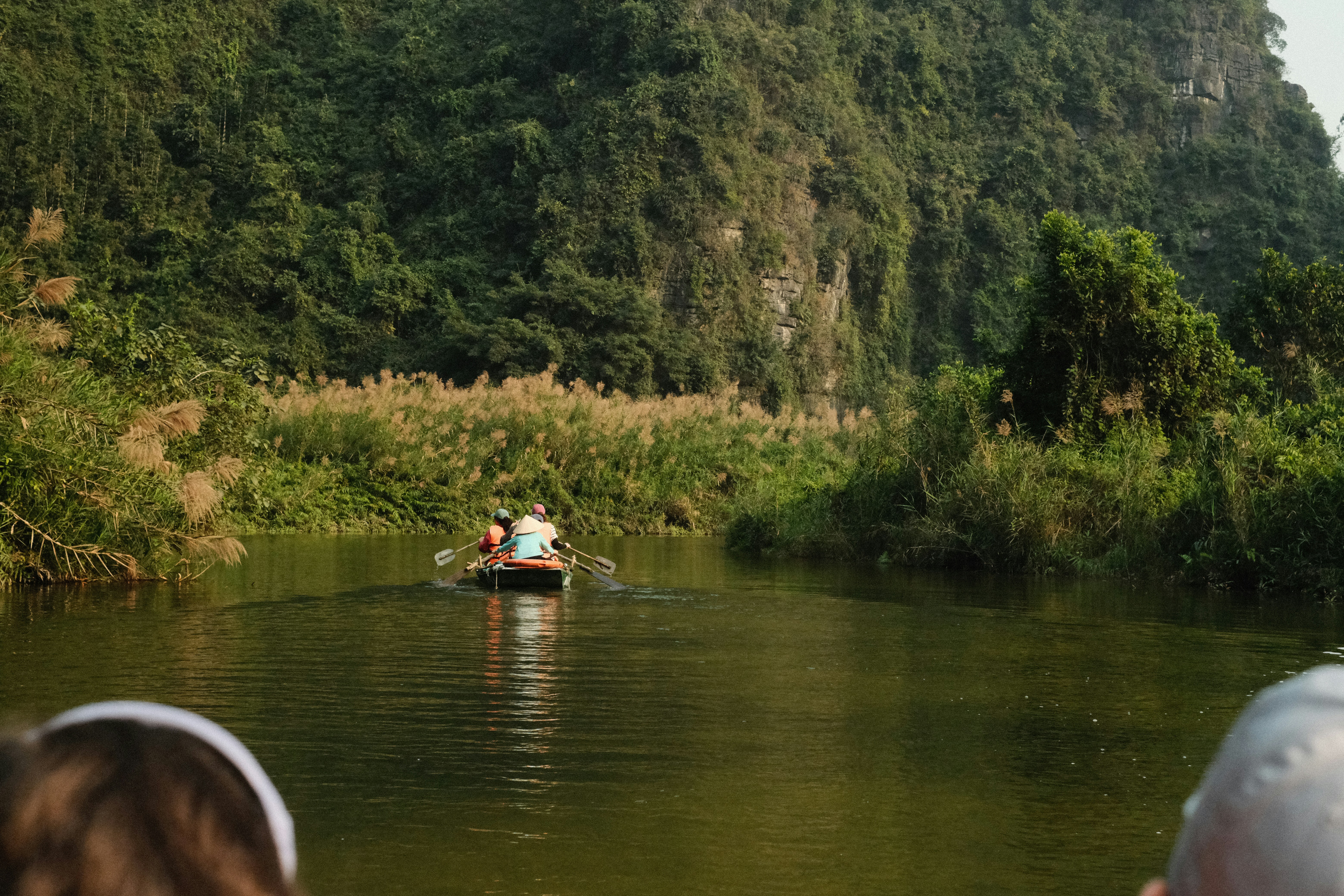 Towards the Quiet Bend: A Boat Glides Between Riverbank Aglow