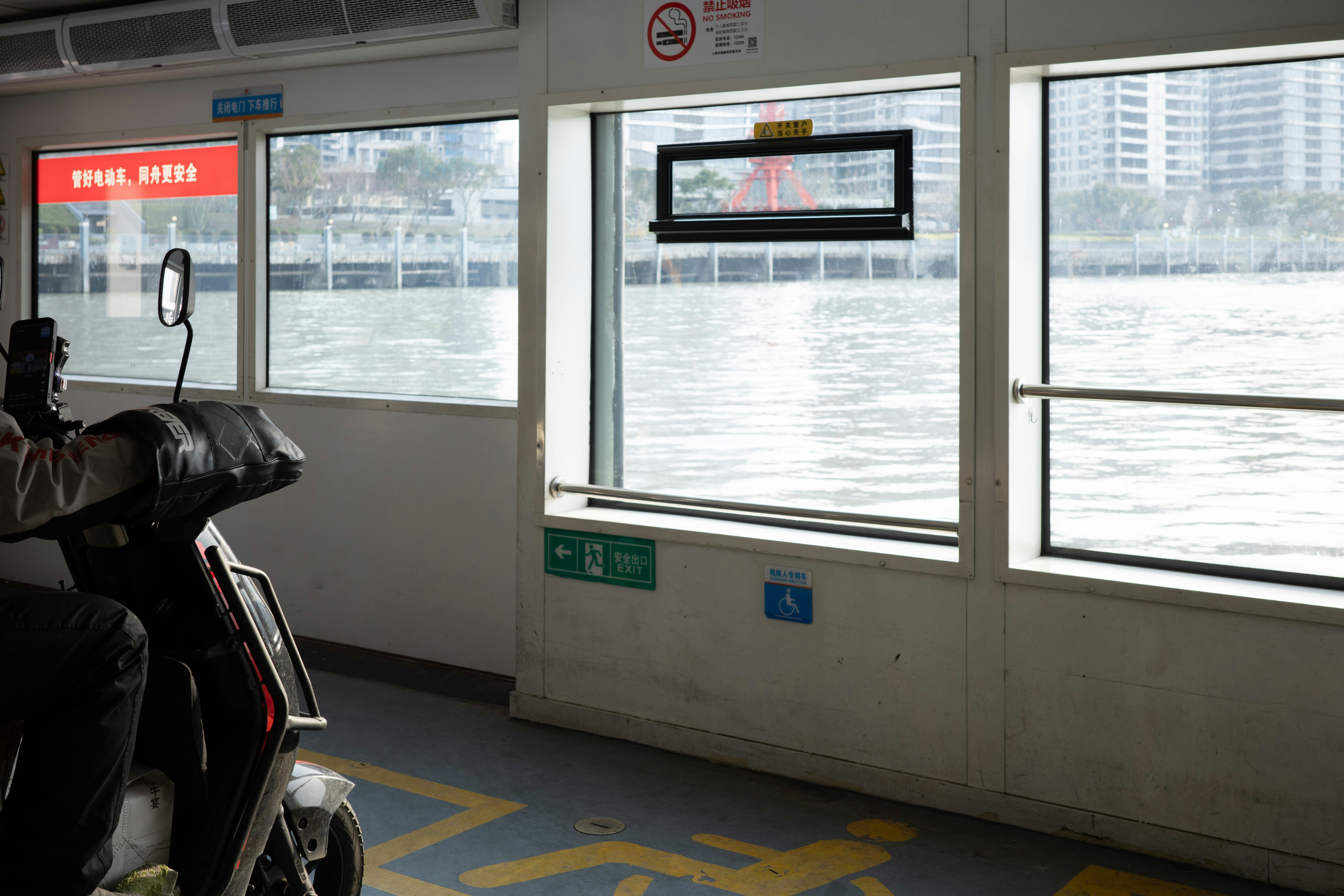 Docked ride across the river: a ferryboat’s interior with a scooter waiting at the window