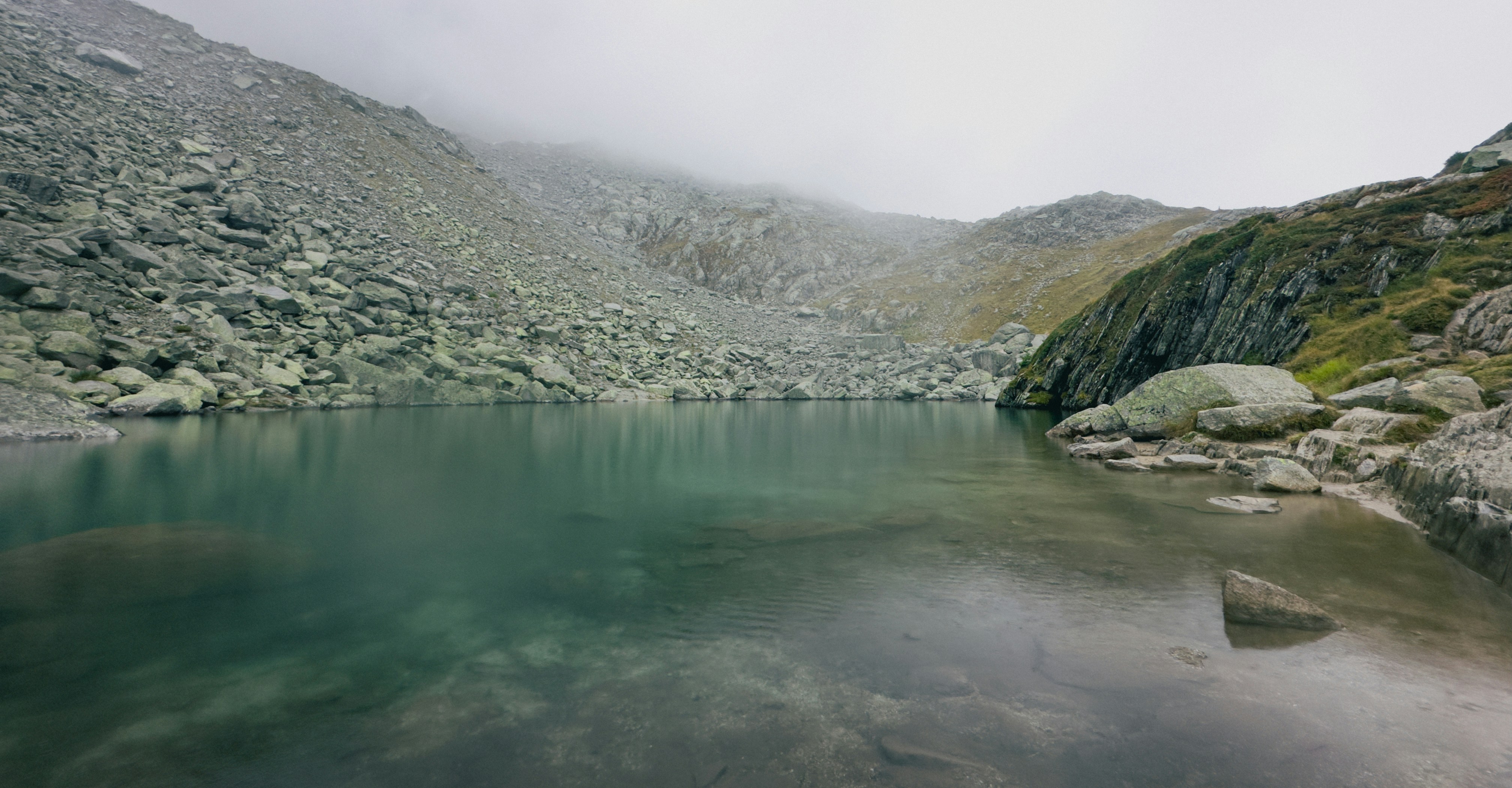 Glacial Basin Mirror: A Quiet Alpine Lake Surrounded by Stones
