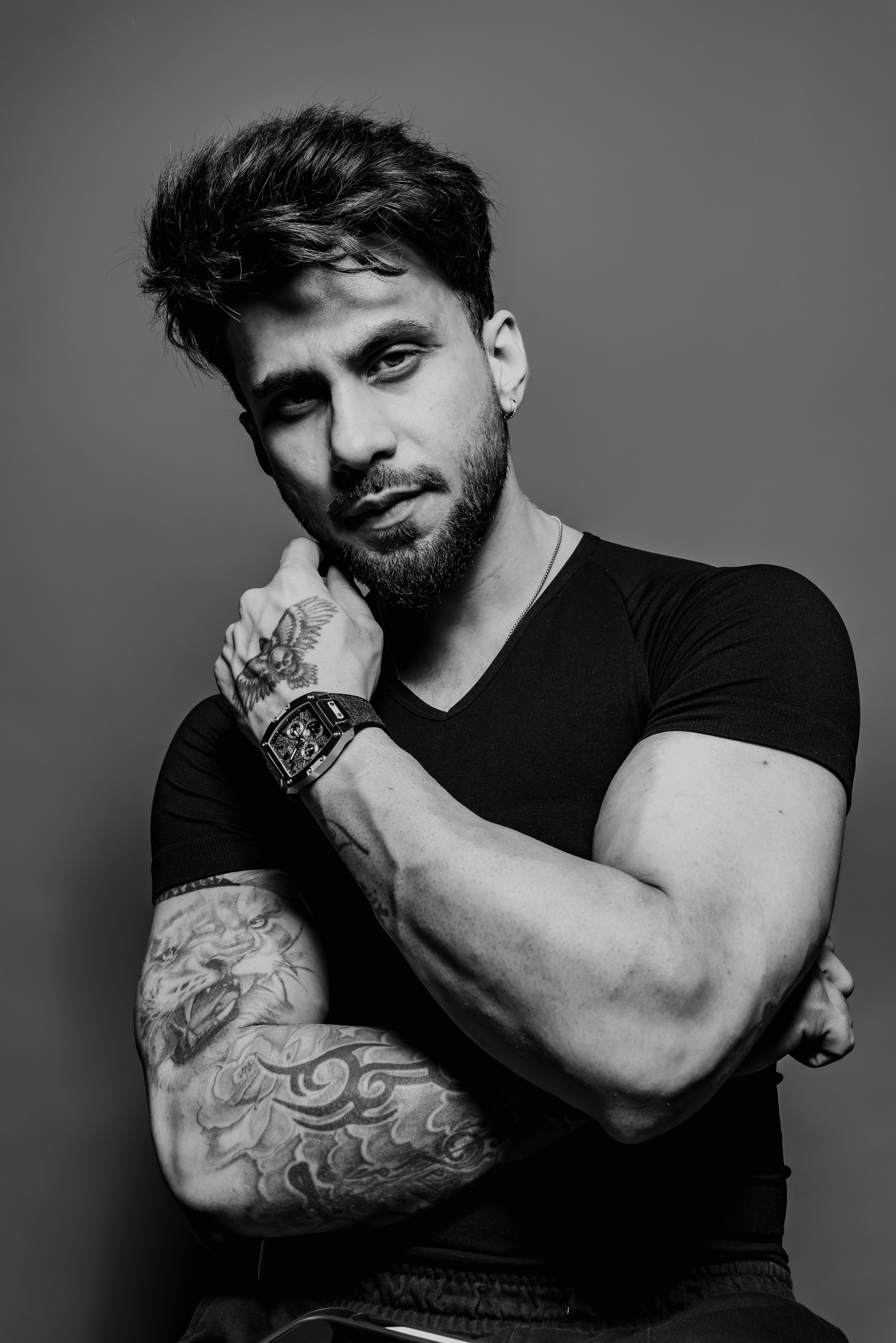 Chiseled resolve: a monochrome portrait of a tattooed man in contemplation