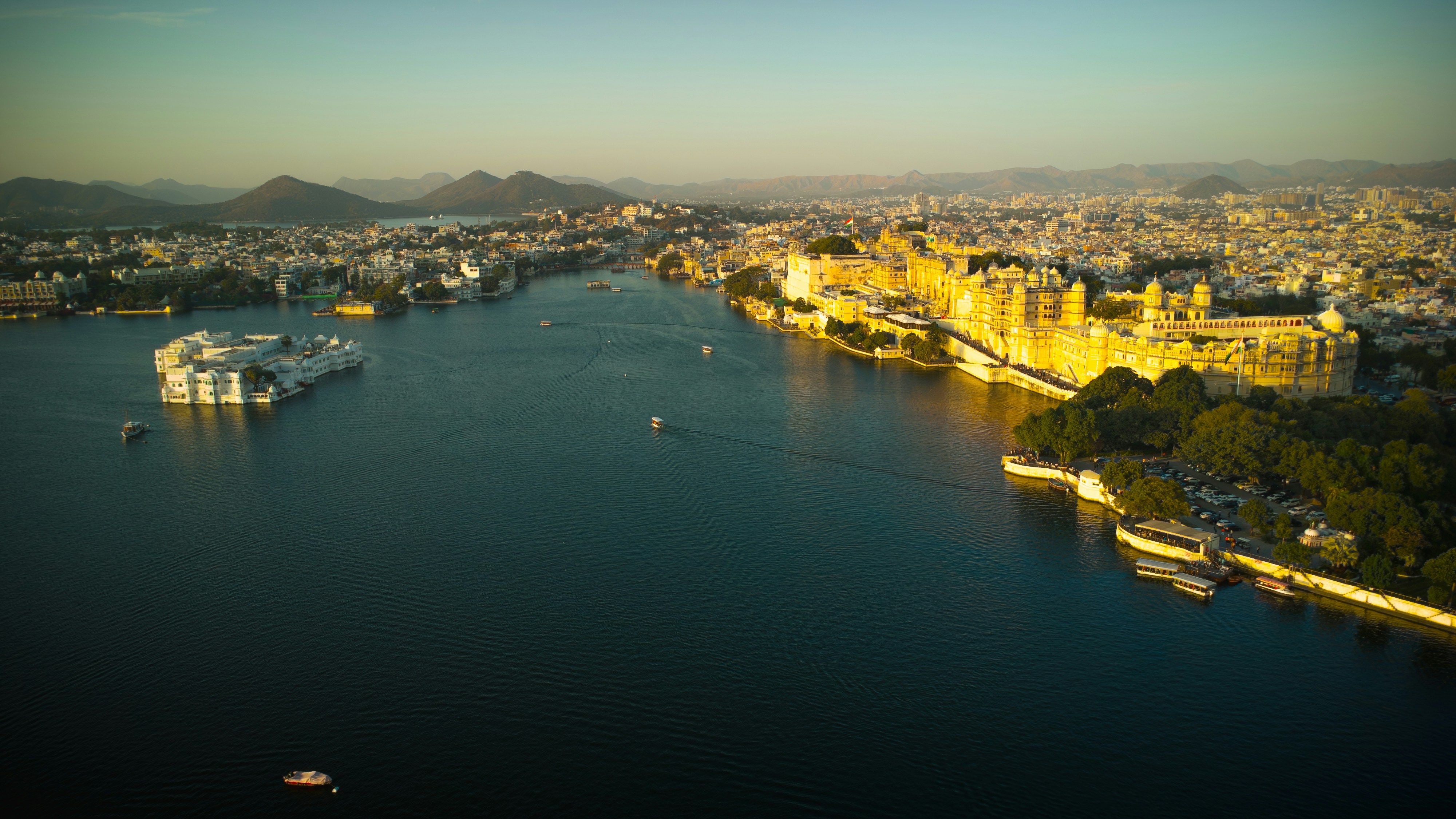 Golden palace buildings on the shore of a wide lake.