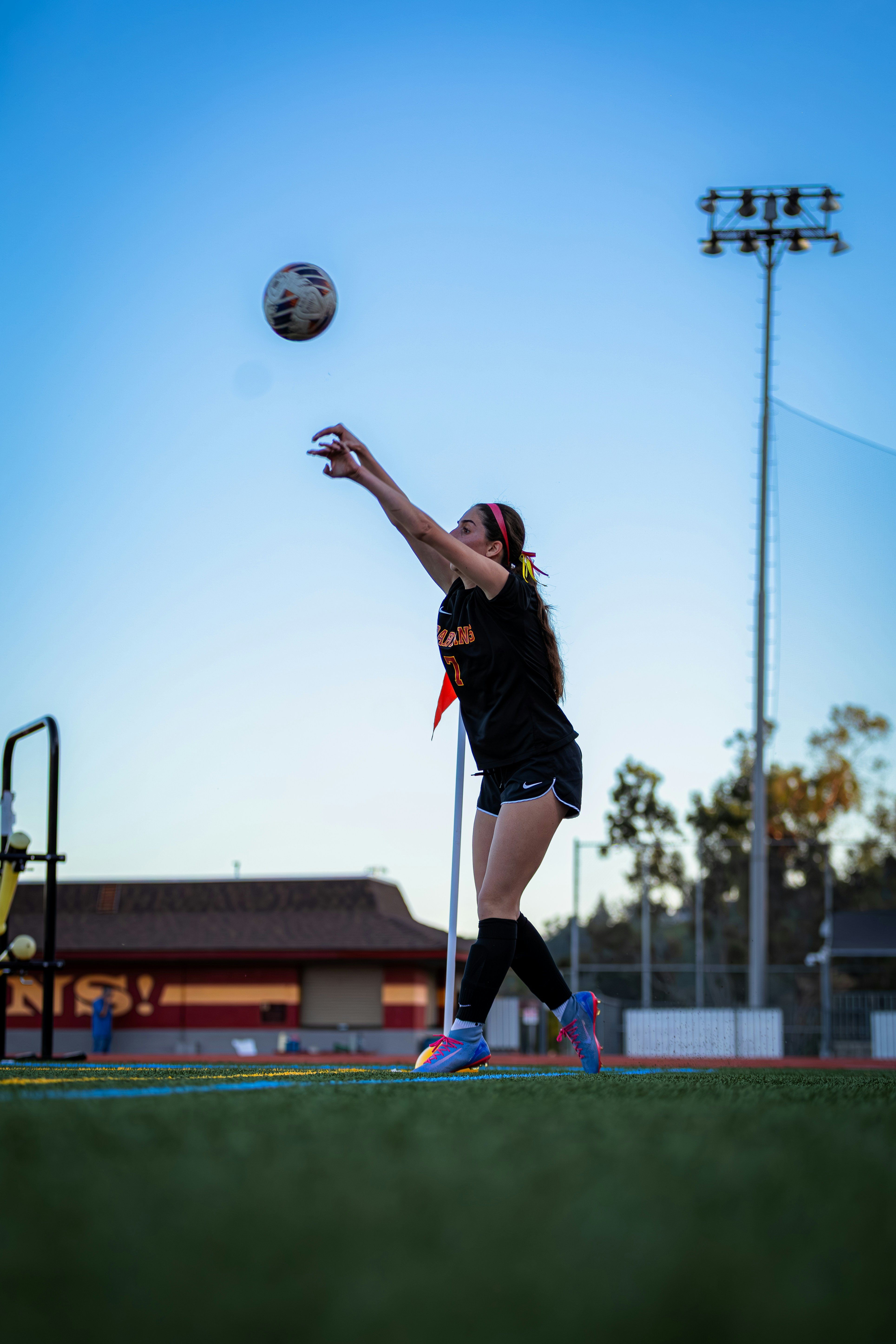 Gravity in Play: A Female Volleyball Player Reaches for the Ball on a Sunny Field
