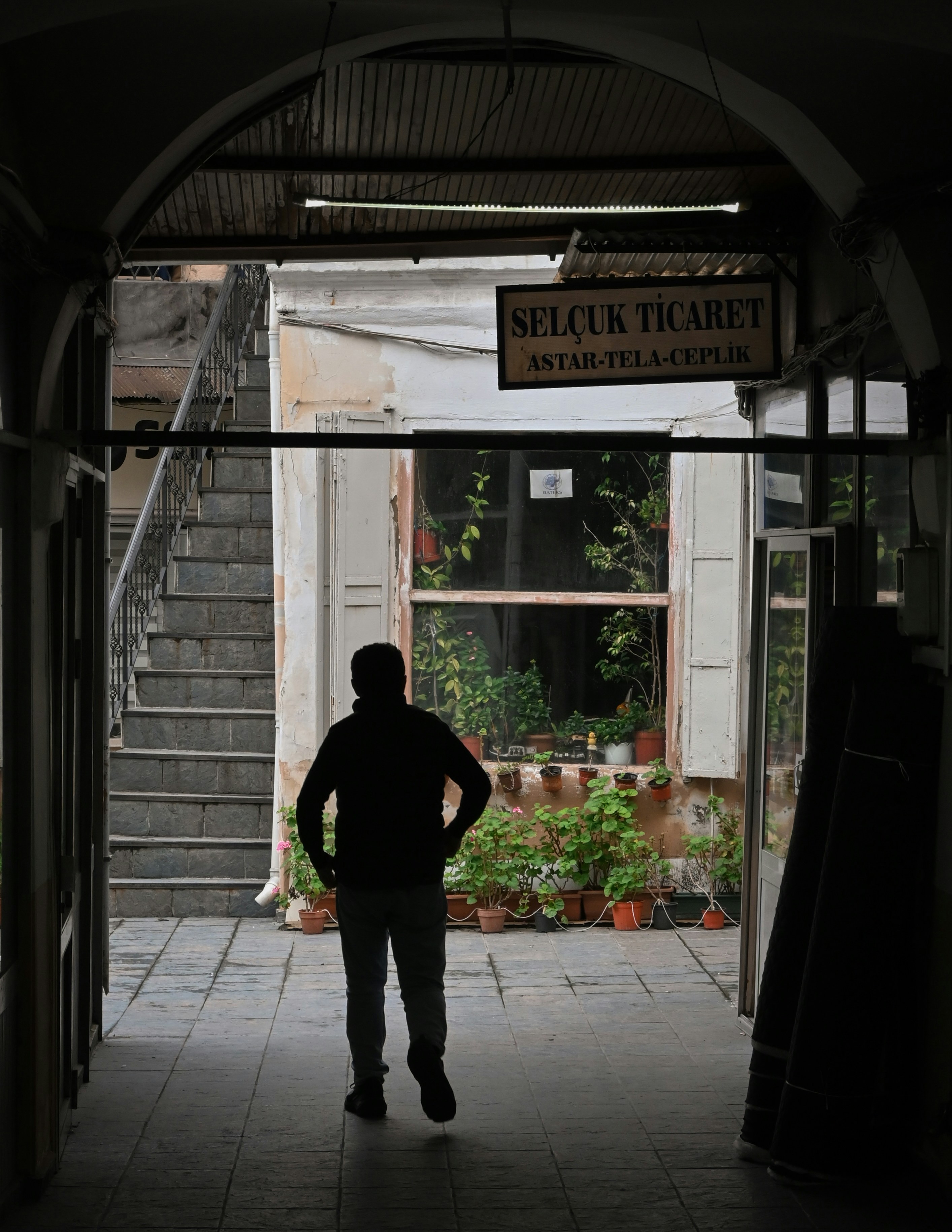 Silhouette in the Courtyard: A Quiet Moment Under the Arch