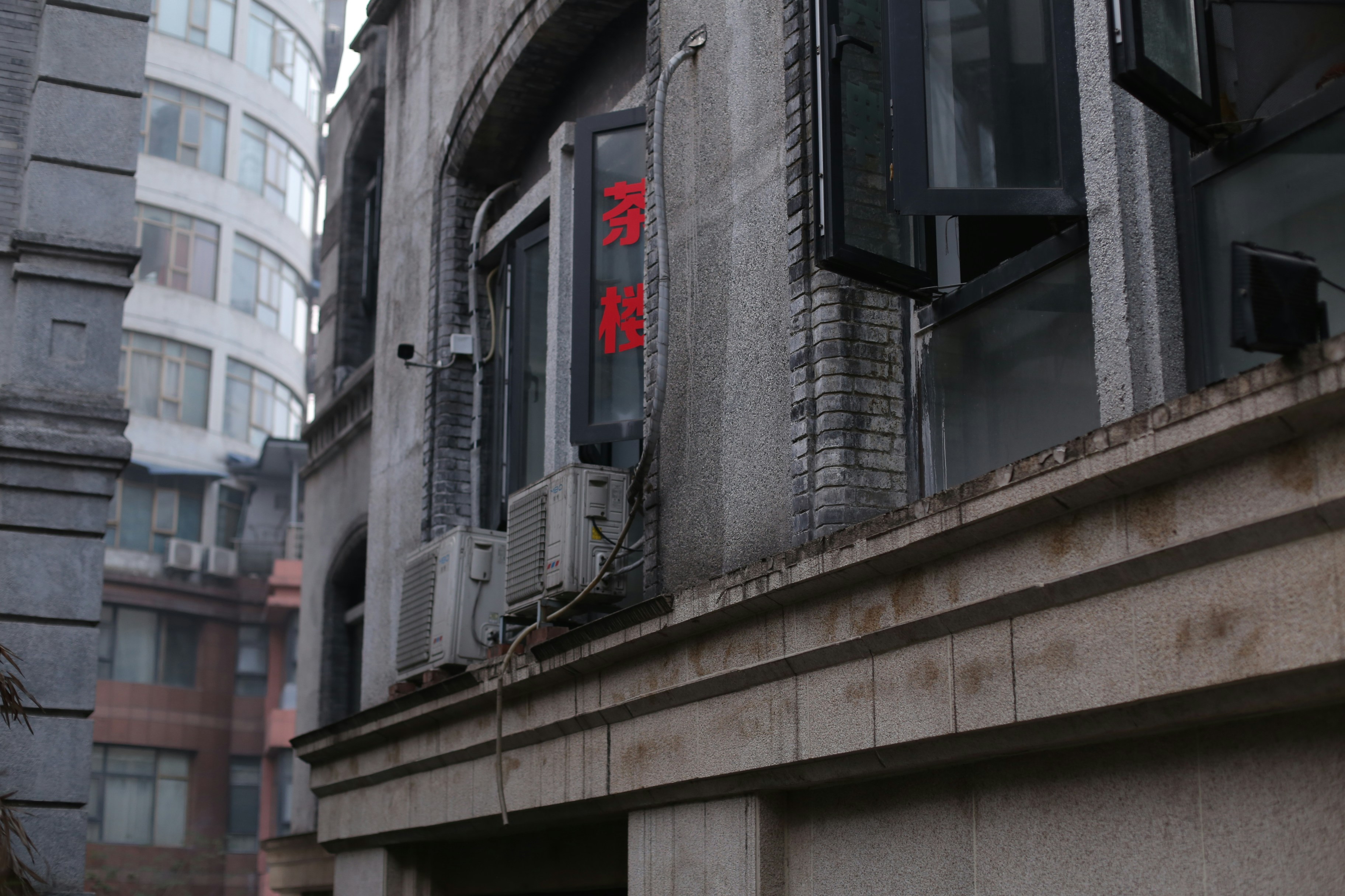 Red Neon Sign on City Facade Amid Concrete Architecture
