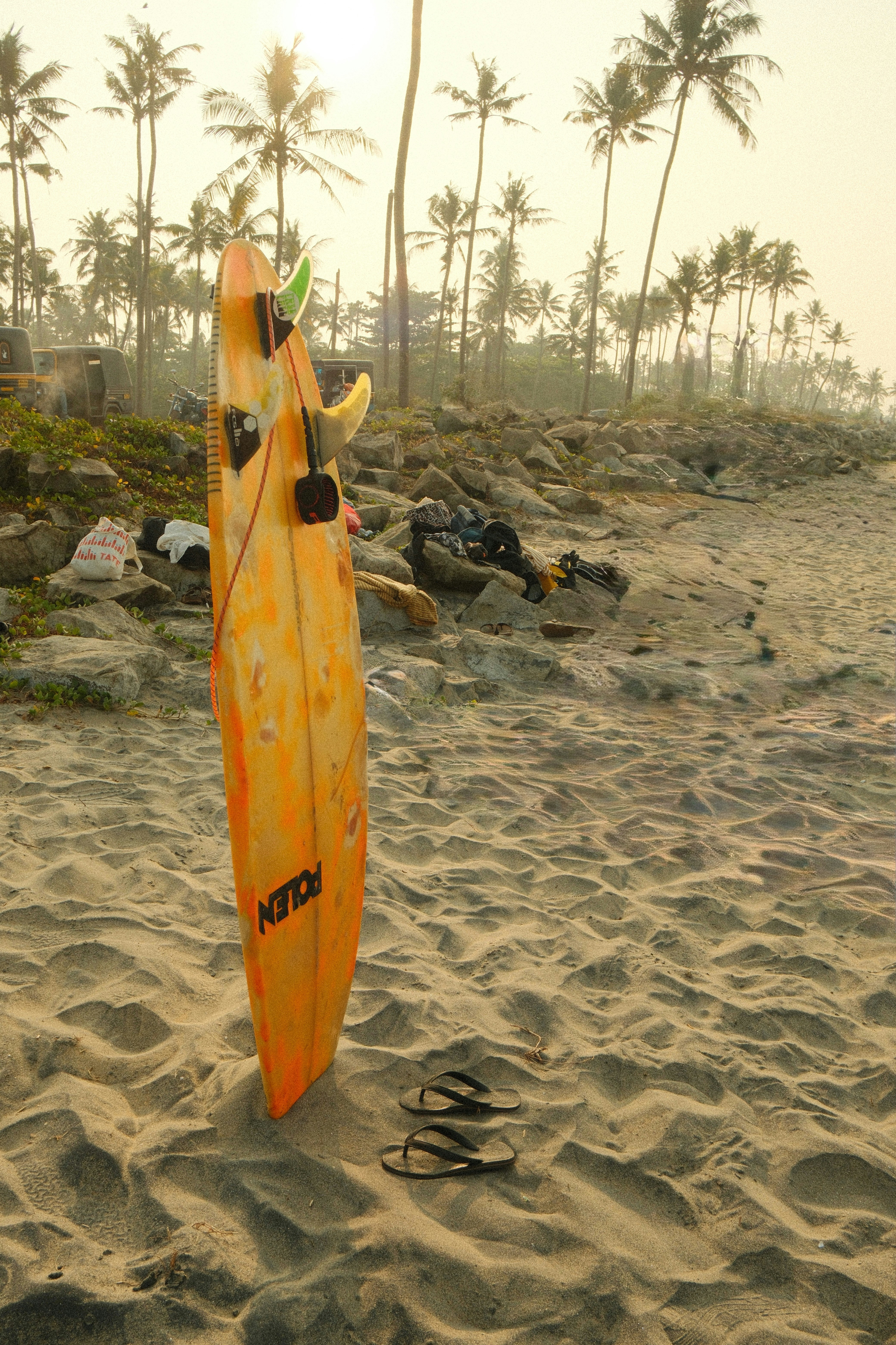 Orange Surfboard Stabbed in Golden Sand Beneath Sunset Palms
