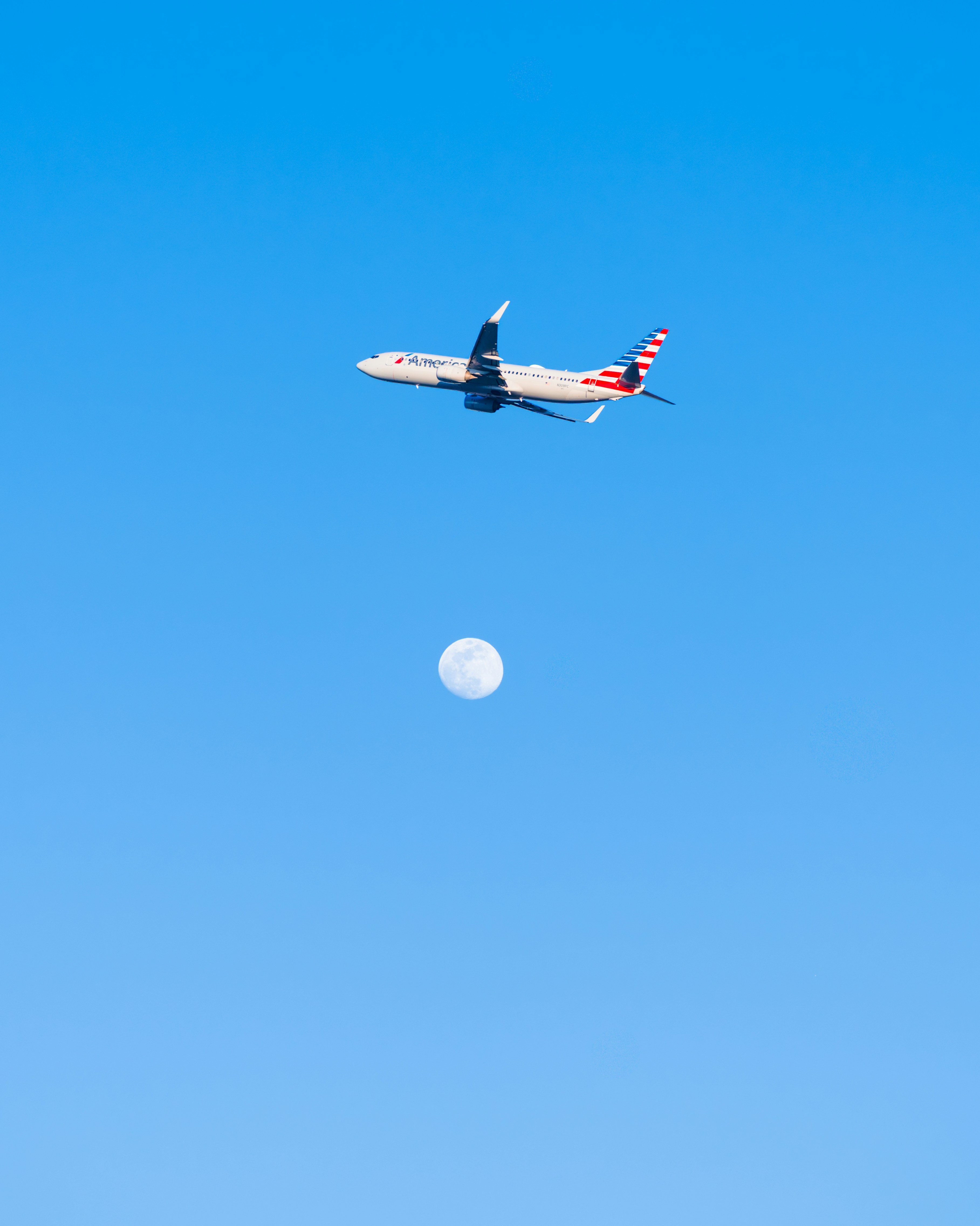 Airliner in Clear Sky: A Transcontinental Moment with the Moon