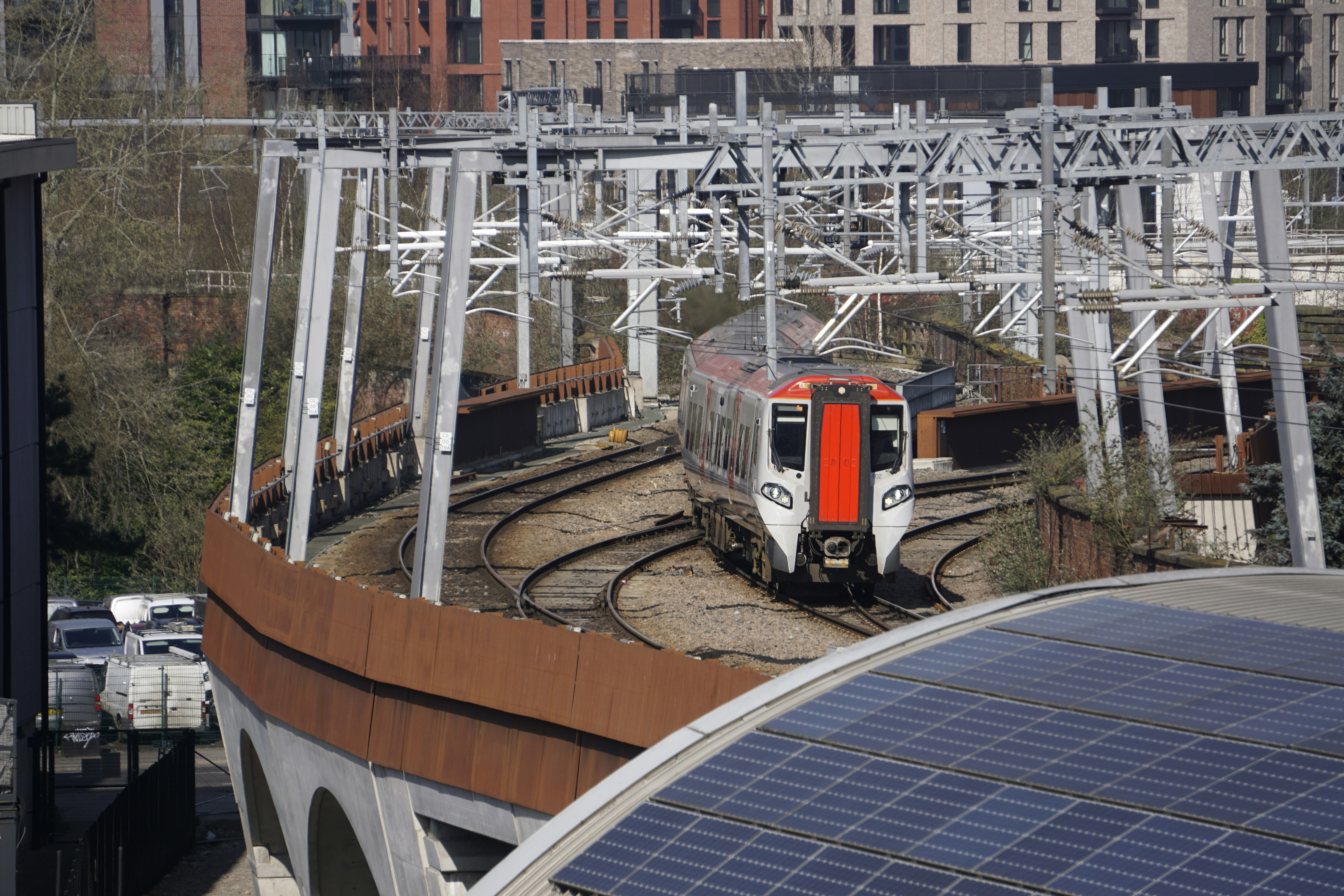 Curved Tracks, Red-Fronted Train Navigating Urban Steel