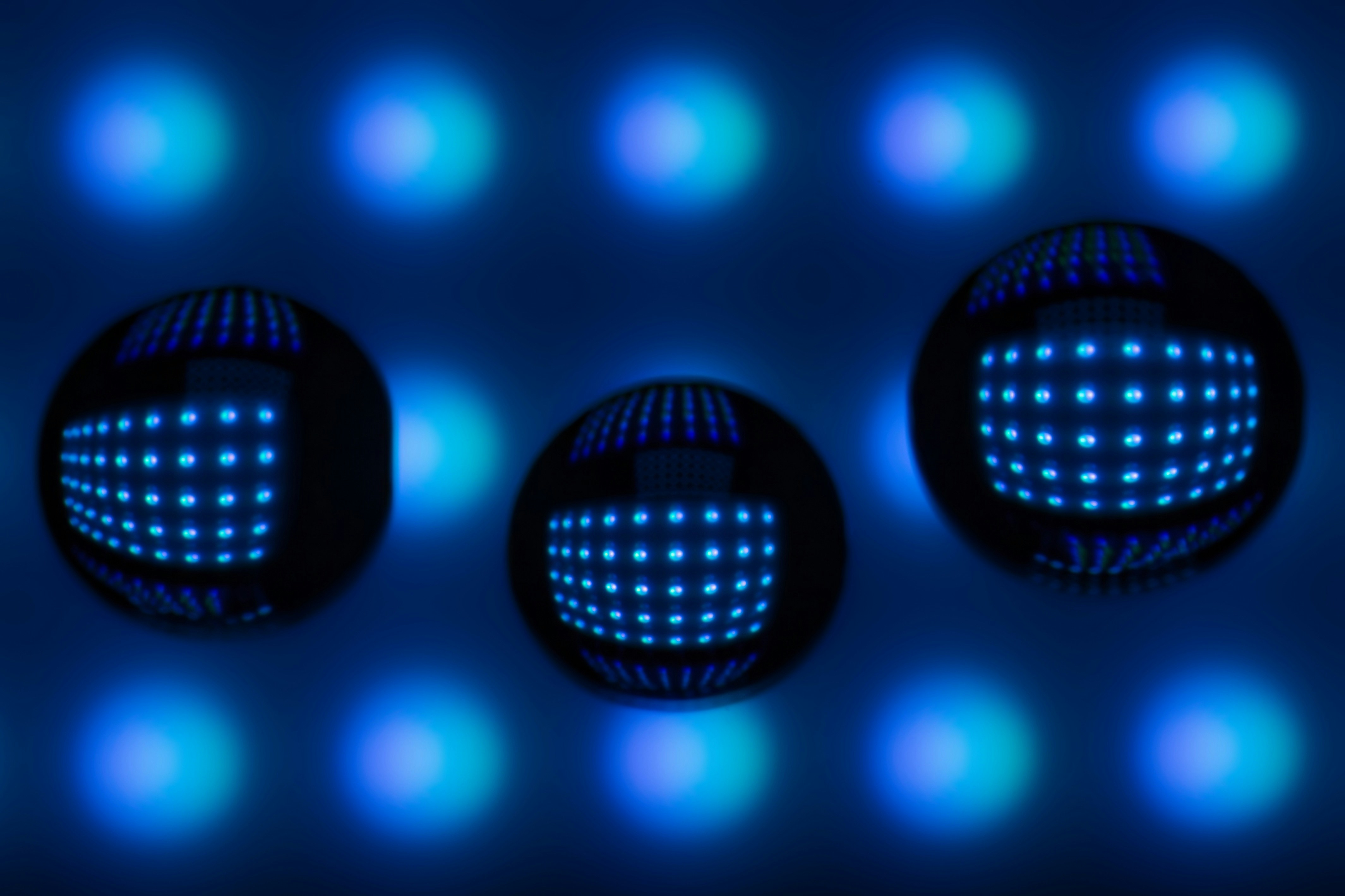 Three Neon Orbs: Blue Grid Reflections in a Velvet Dark