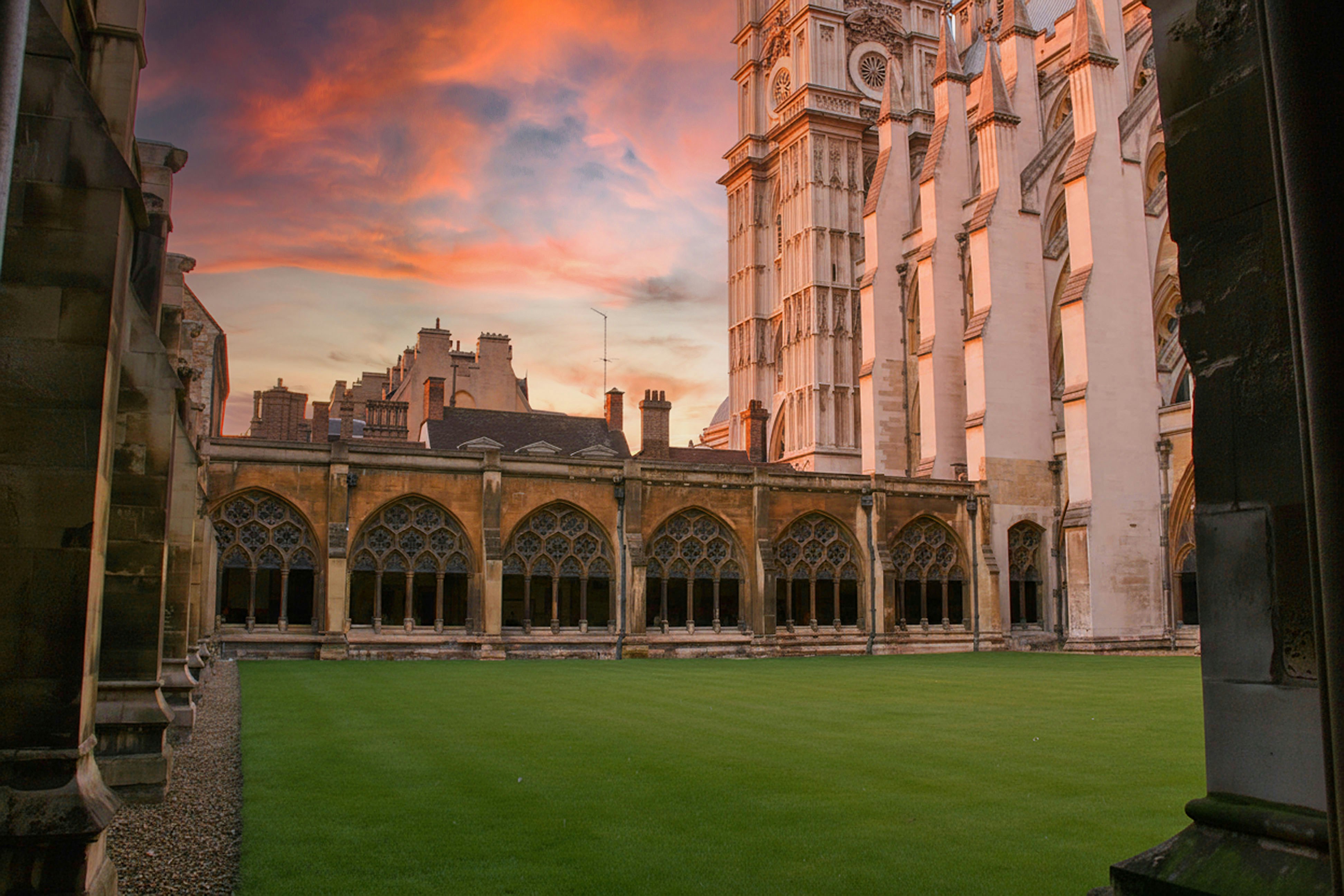 Sunset over Cloister Garden: Gothic Arches Framing a Looming Skyline