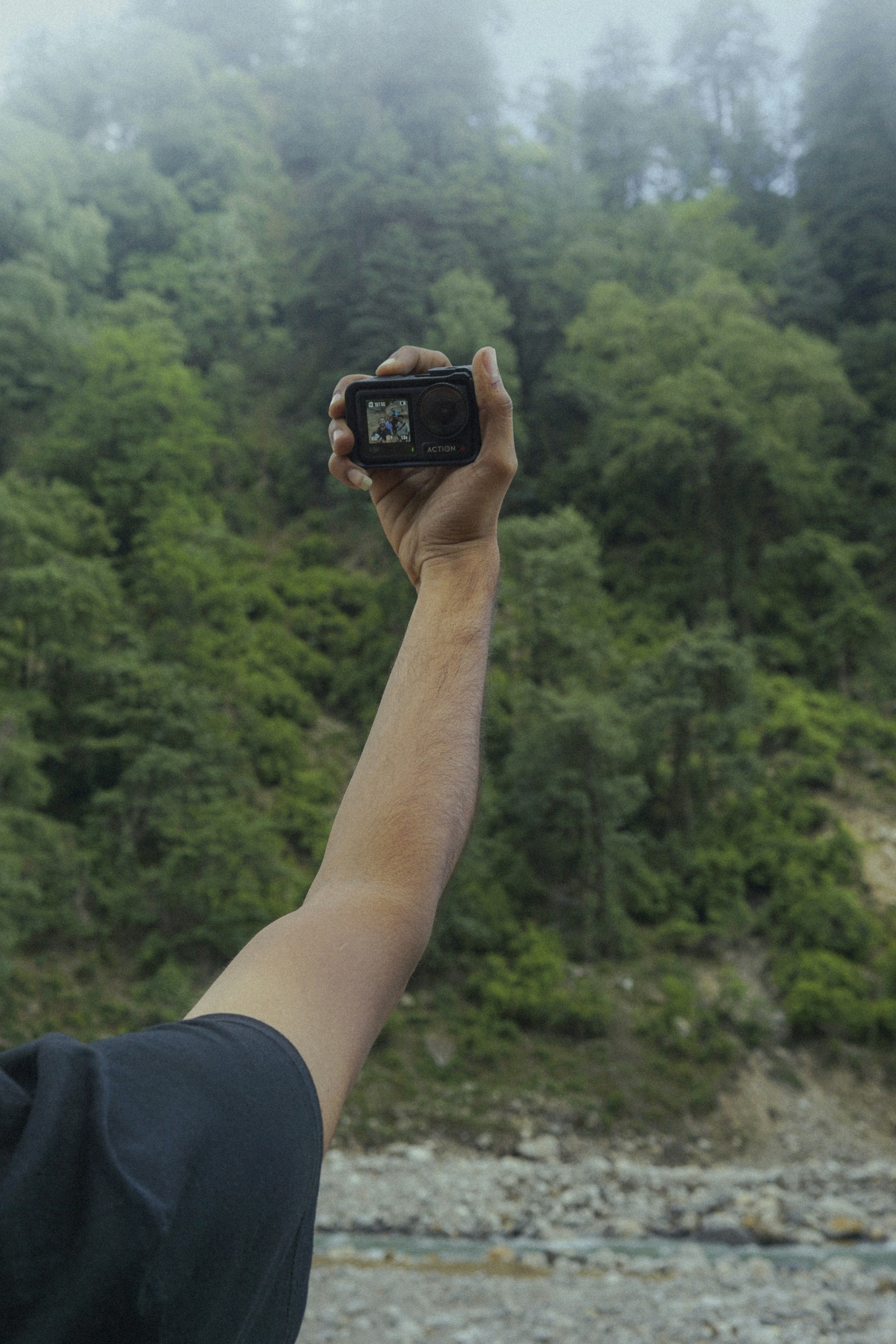 Rising Hand with Action Camera Against Verdant Canyon