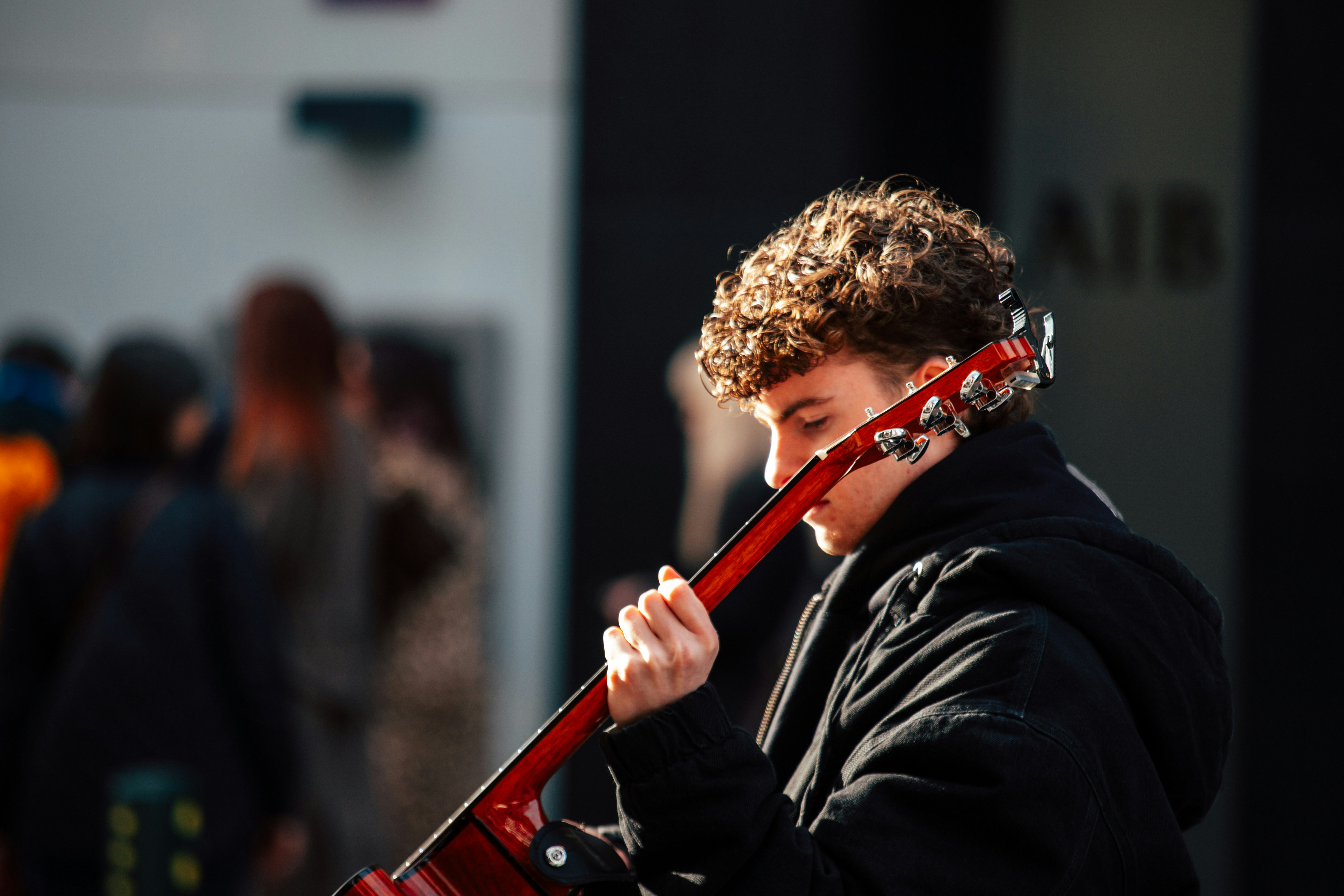 Curled curls and guitar strings: a street musician in the spotlight