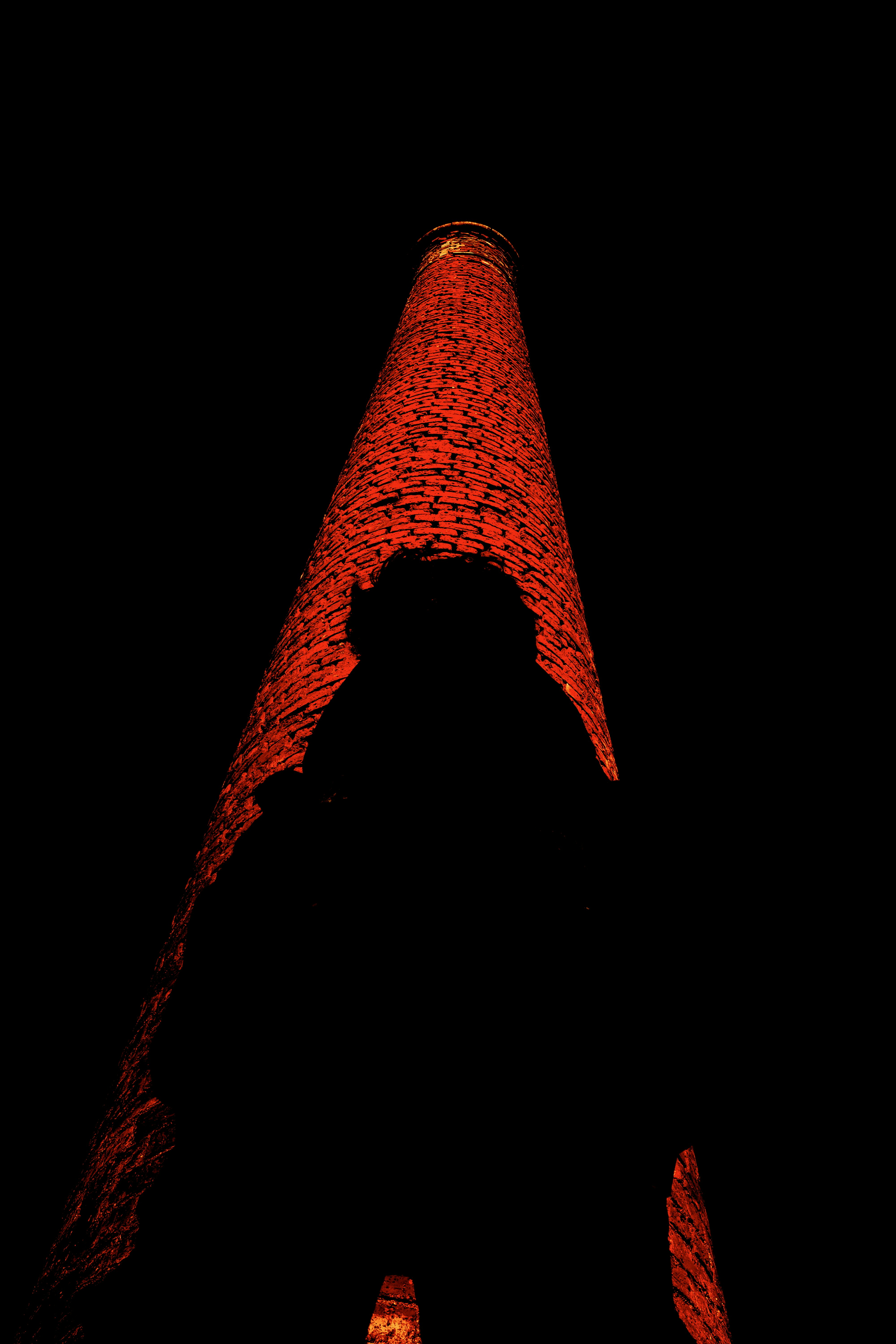 Red Torch in the Dark: A Silhouette Beneath a Towering Flame