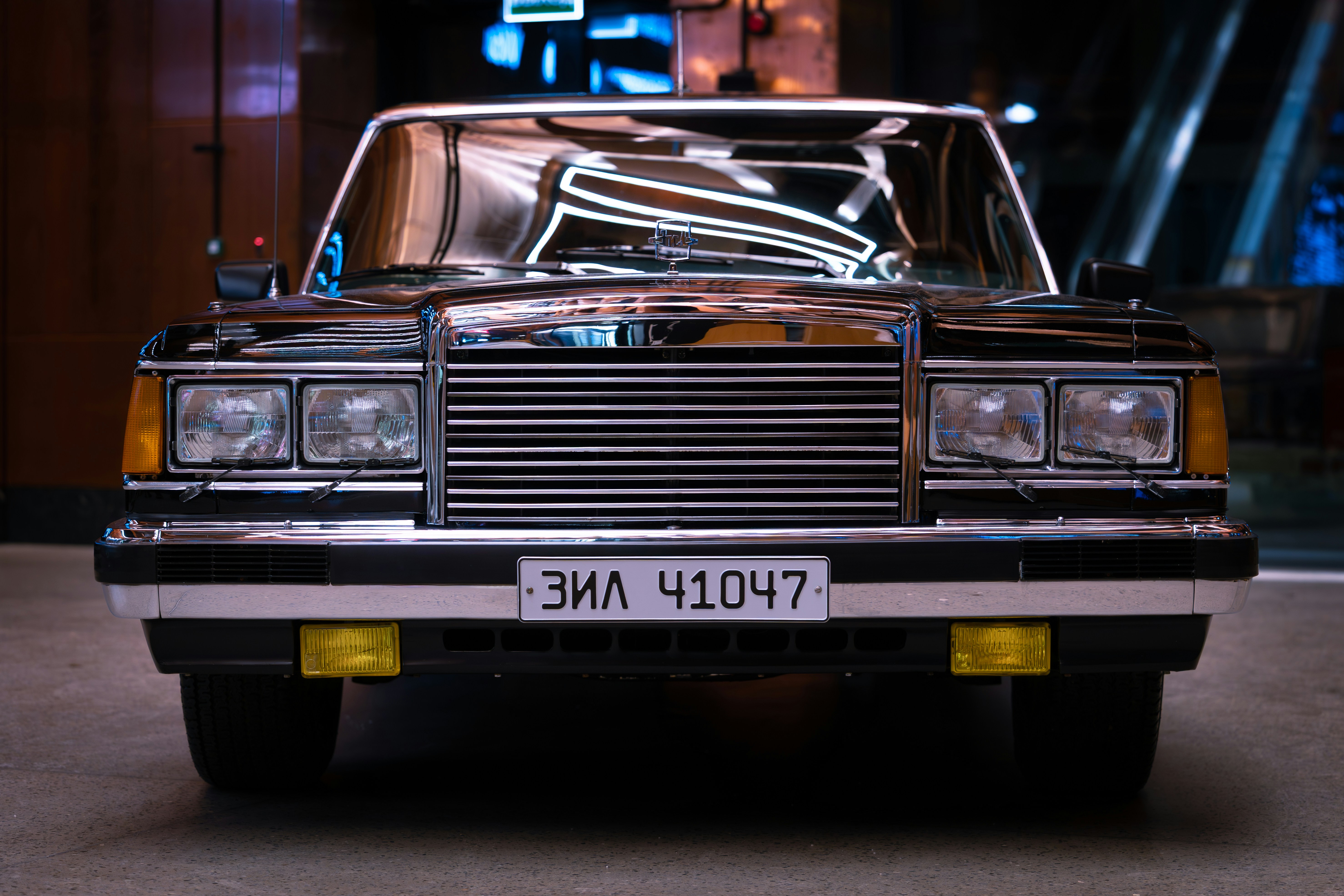 Front-and-center: Classic car with chrome grille under neon glow