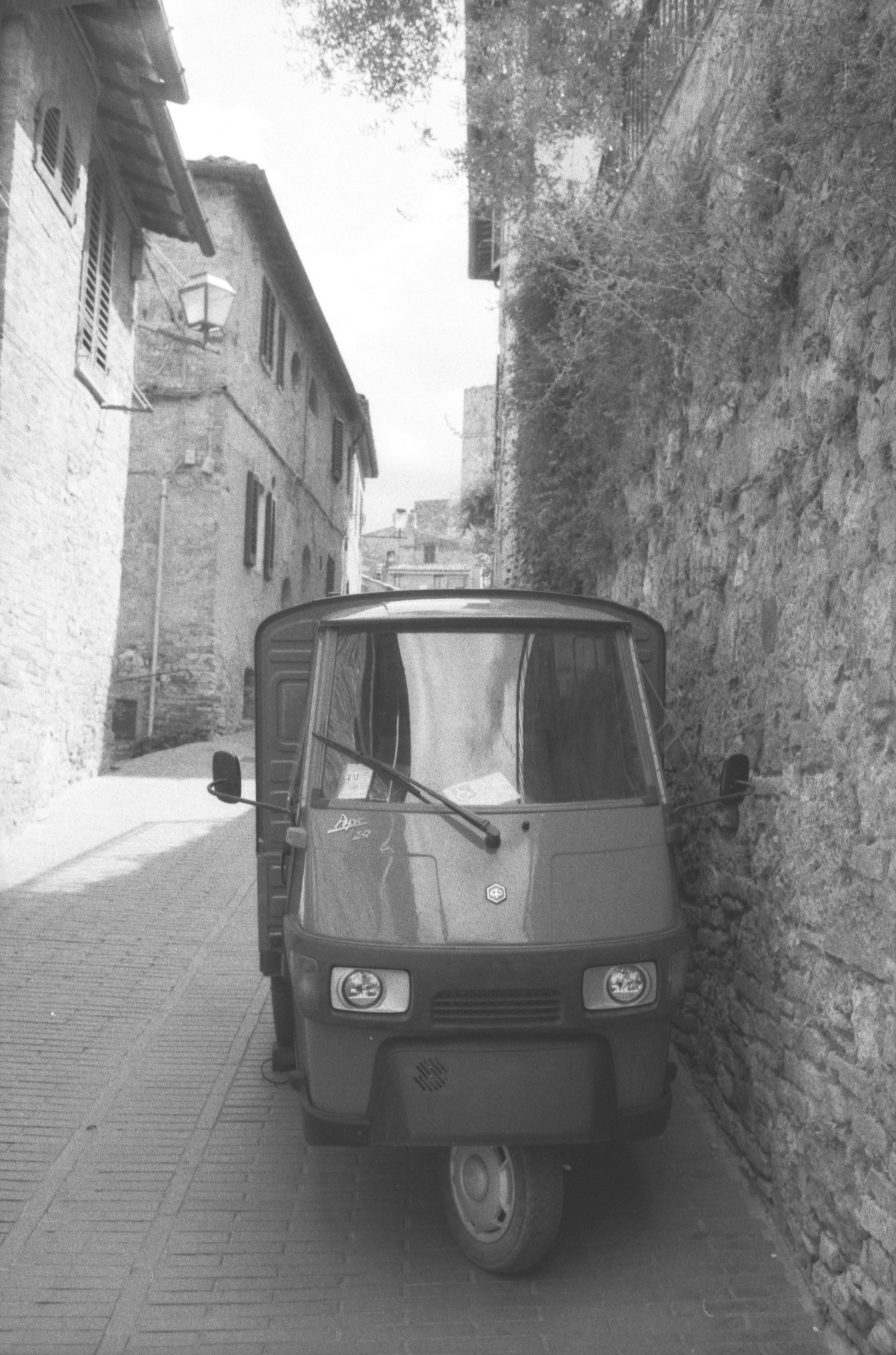 Narrow alleyway with a compact three-wheeled vehicle facing forward