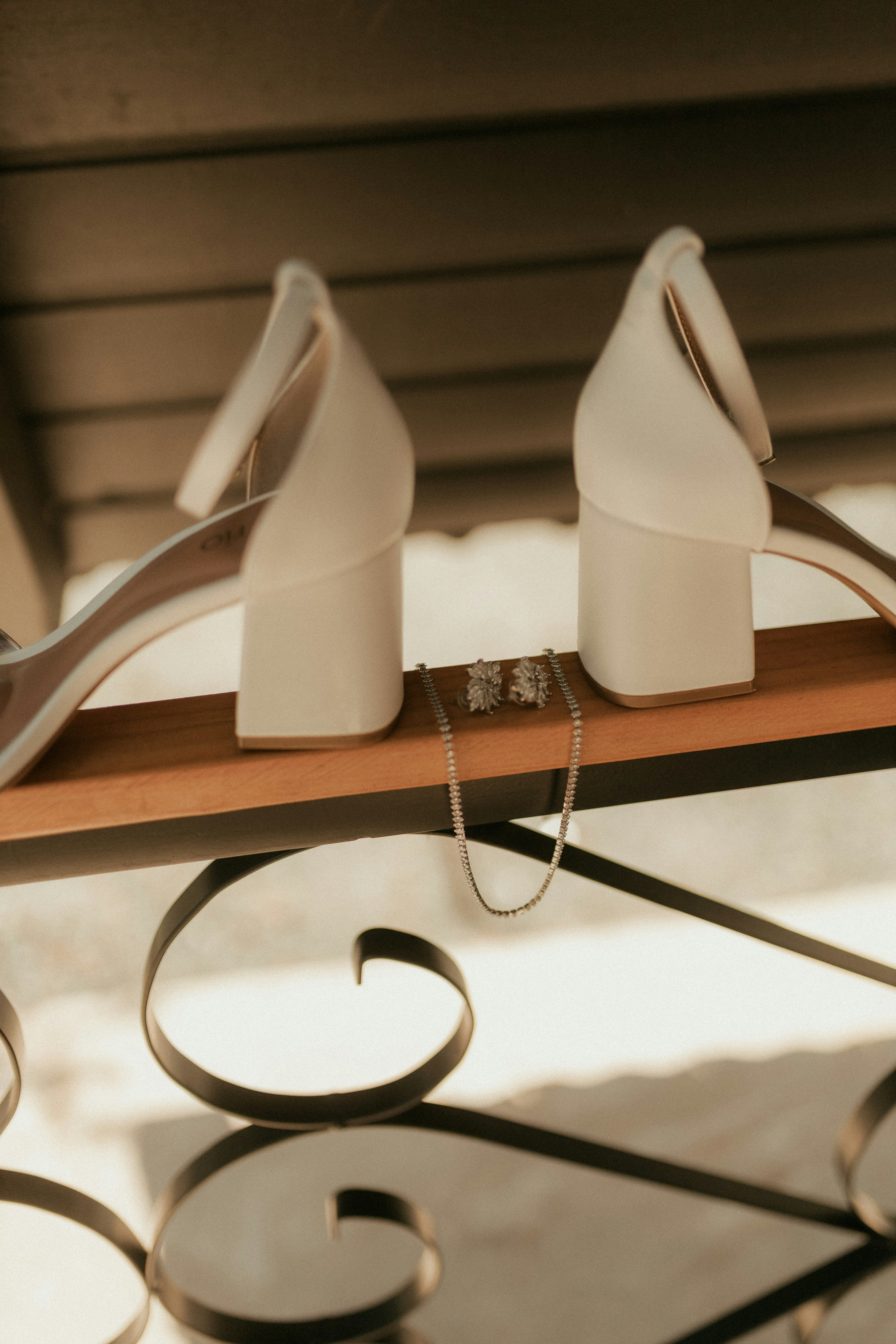 Bride’s Heels and Charm: A Delicate Necklace Dangles Between White Steps