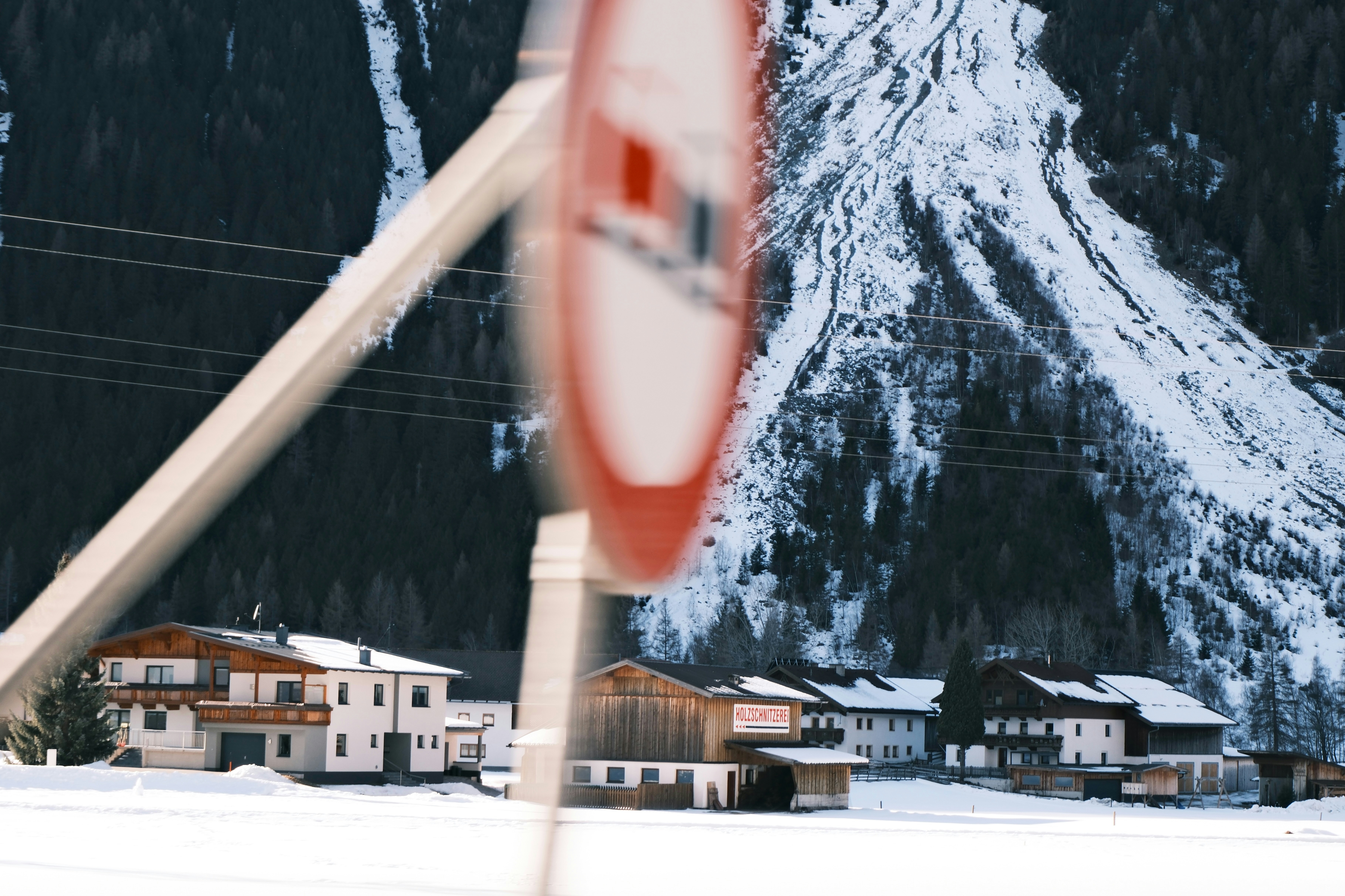 Snowbound Village with Blurred Road Sign and Mountain Backdrop