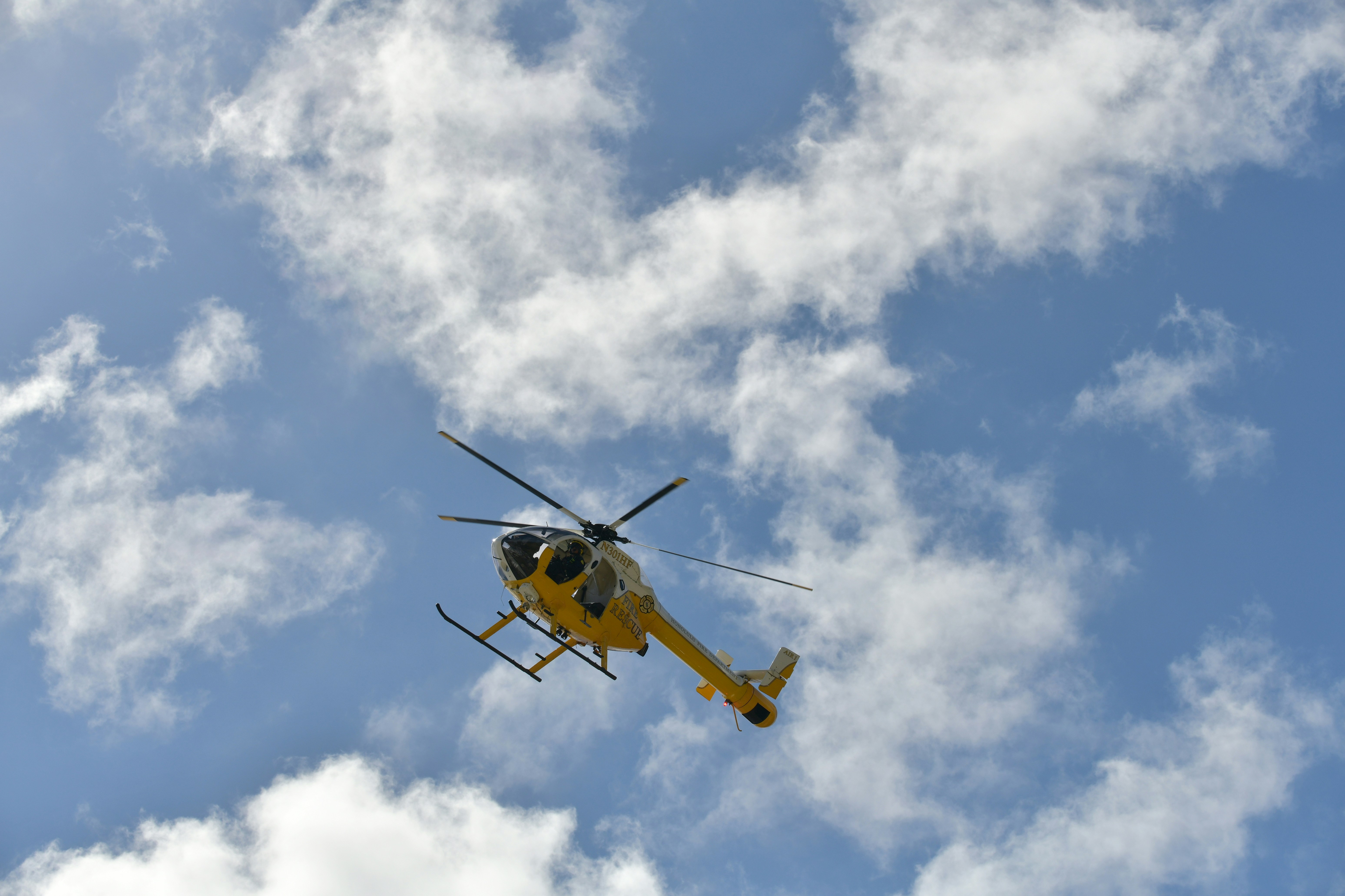 Low-Altitude Yellow Rescue Helicopter in a Bright Sky