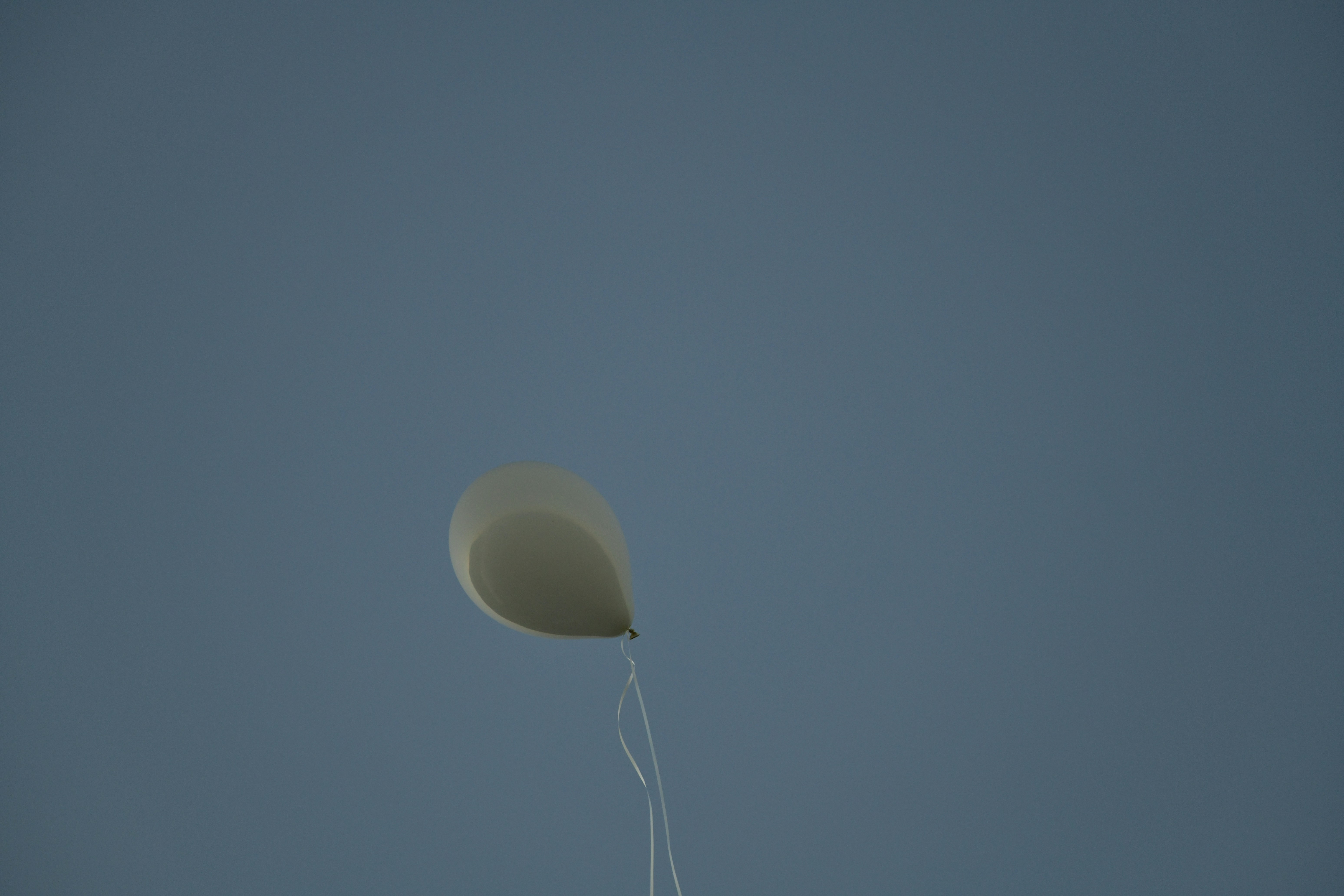 Floating Echo: A lone balloon against a vast blue